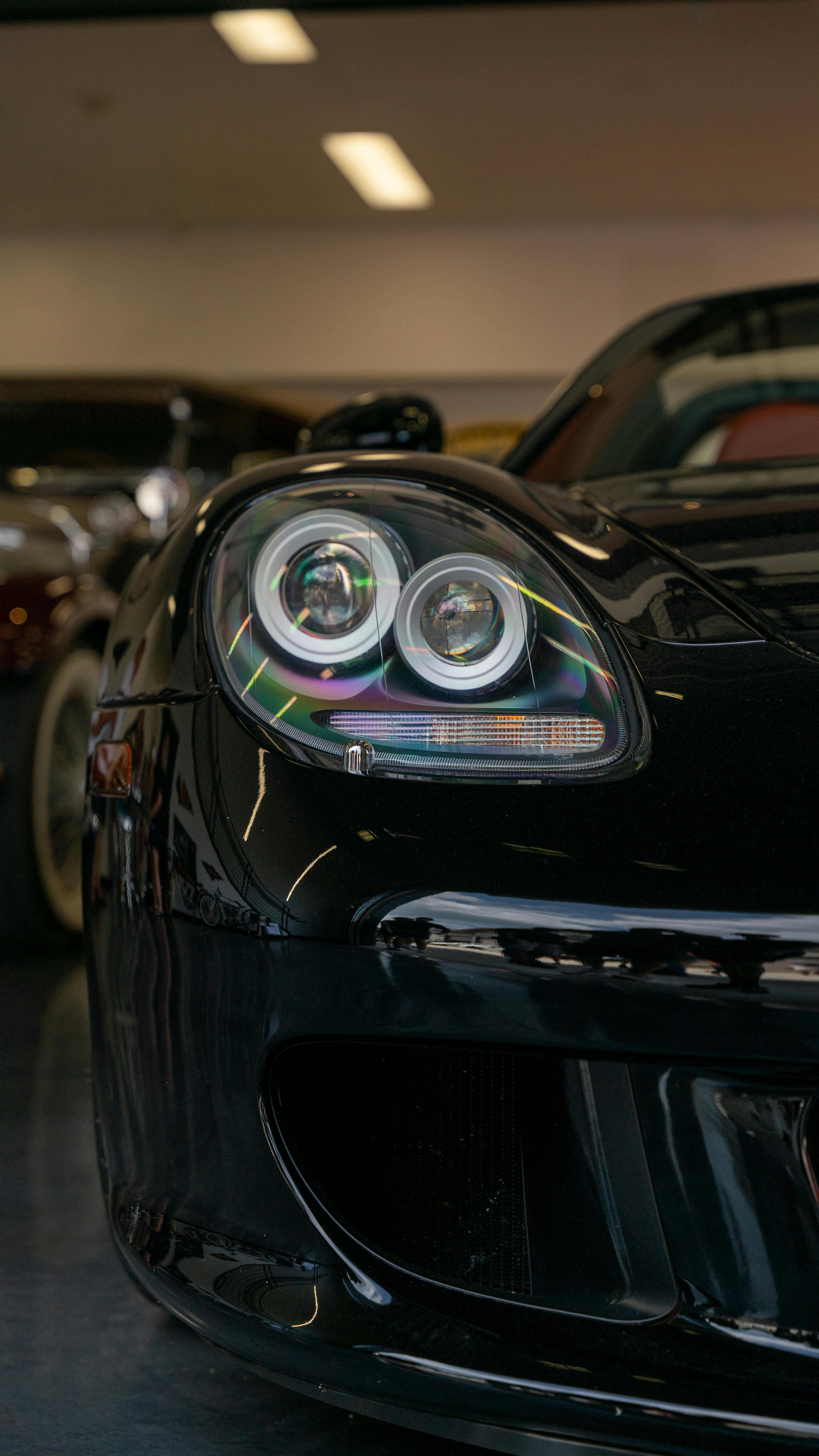 Close-Up of a Sleek Black Sports Car Headlight · Free Stock Photo