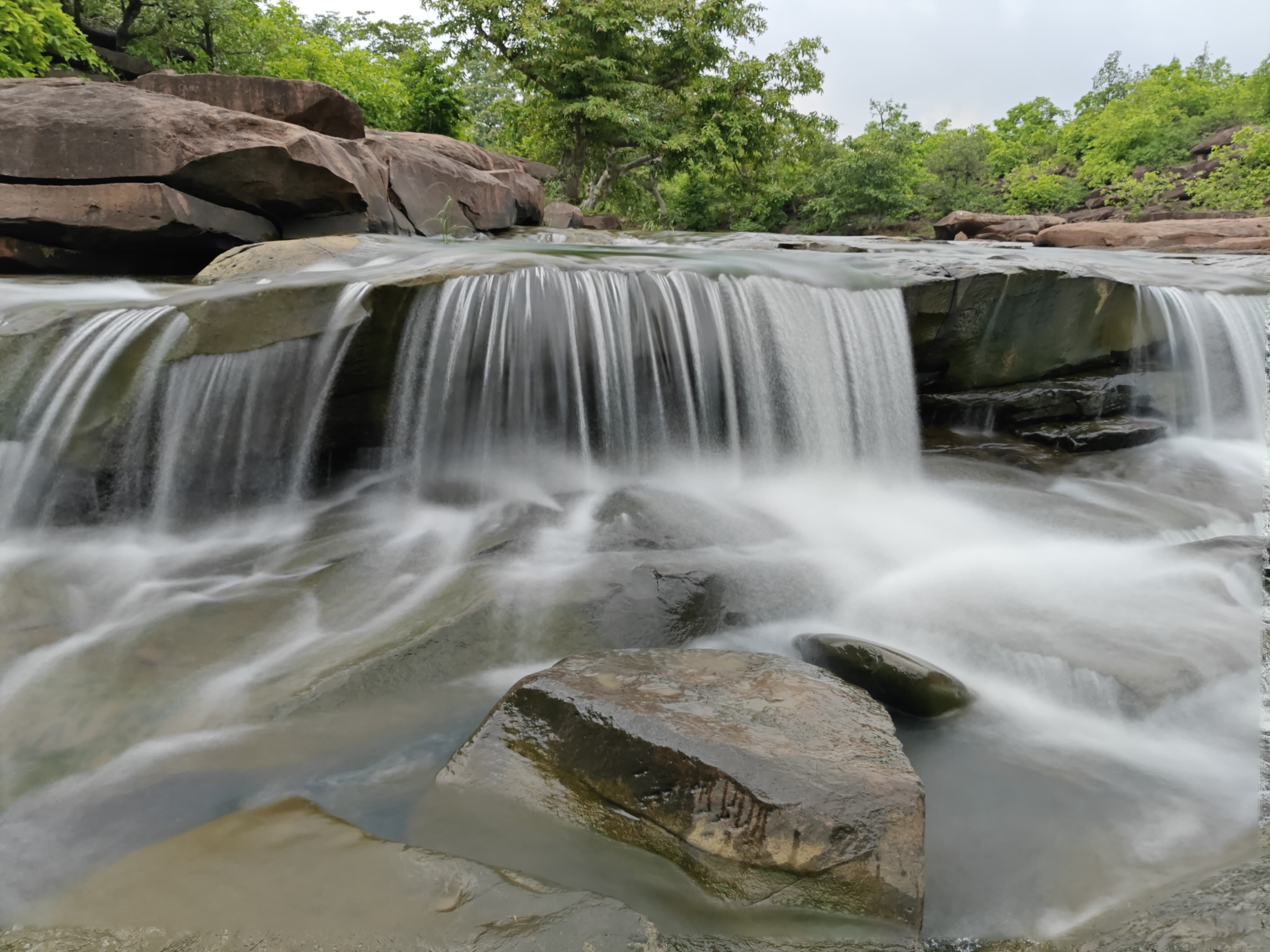 Serene Waterfall Cascading Over Rocky Ledge · Free Stock Photo