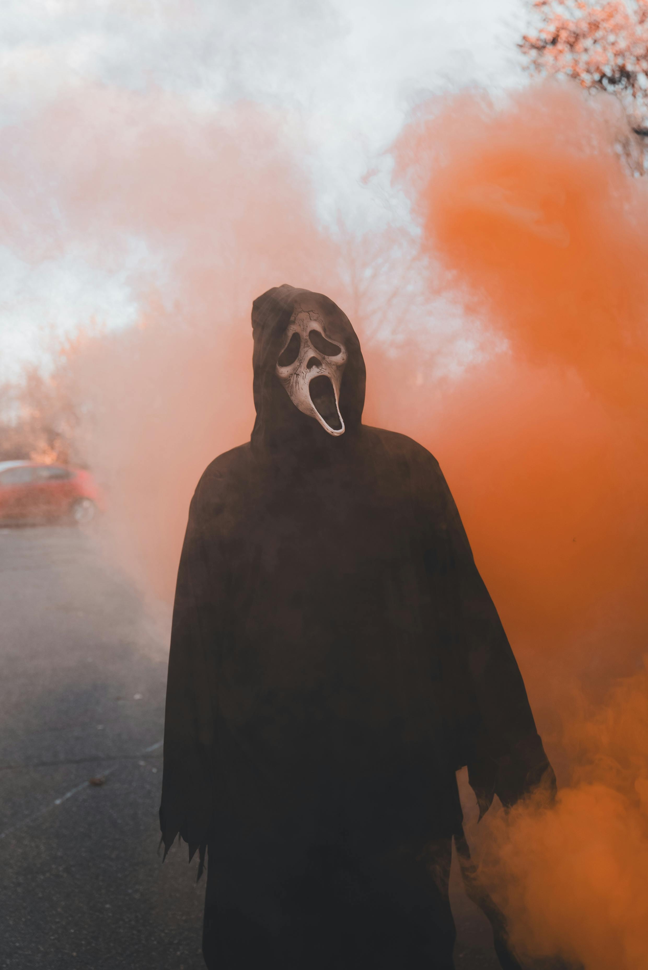 Spooky Figure Amidst Orange Smoke Outdoors · Free Stock Photo