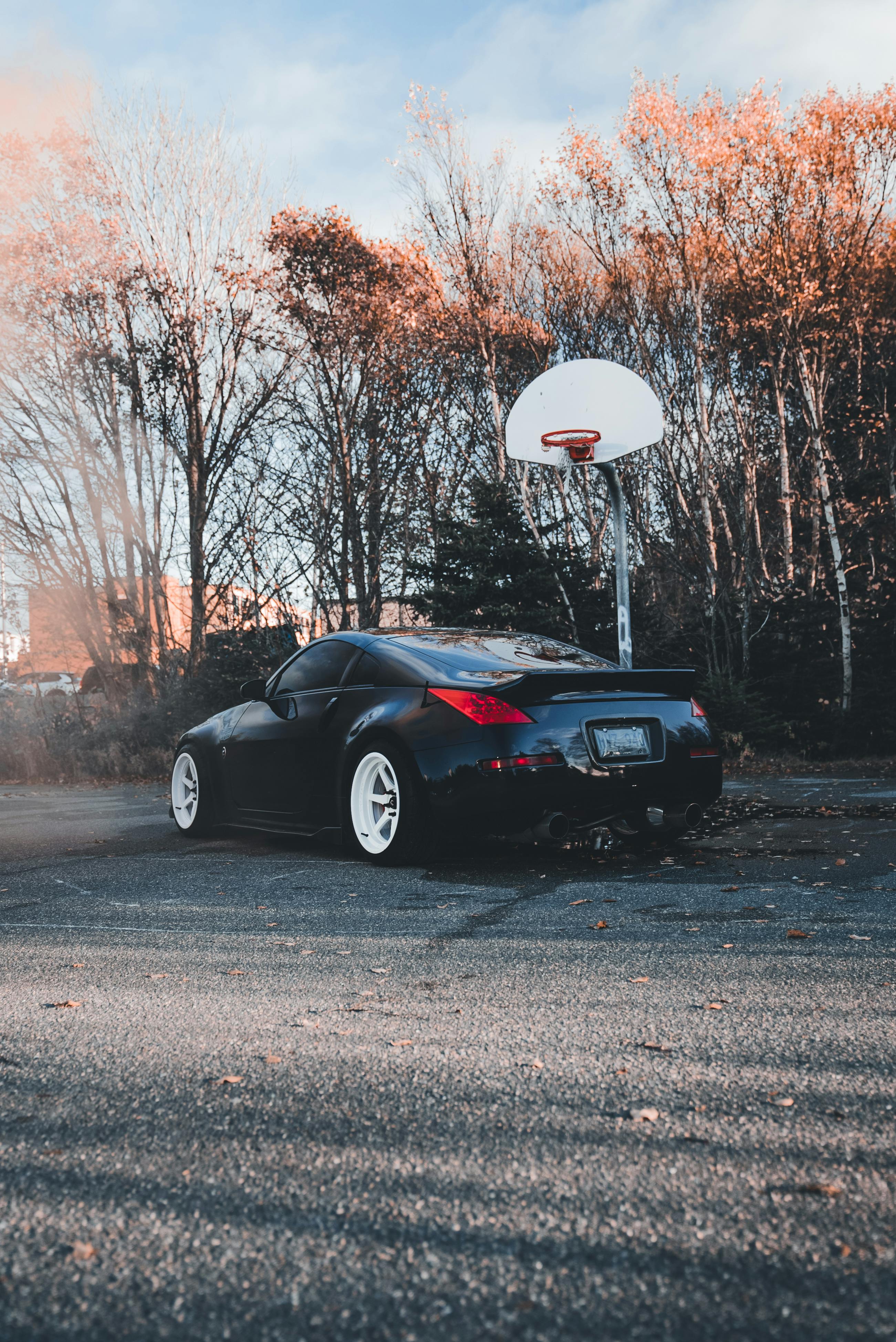 Black Sports Car in Autumn Urban Setting · Free Stock Photo