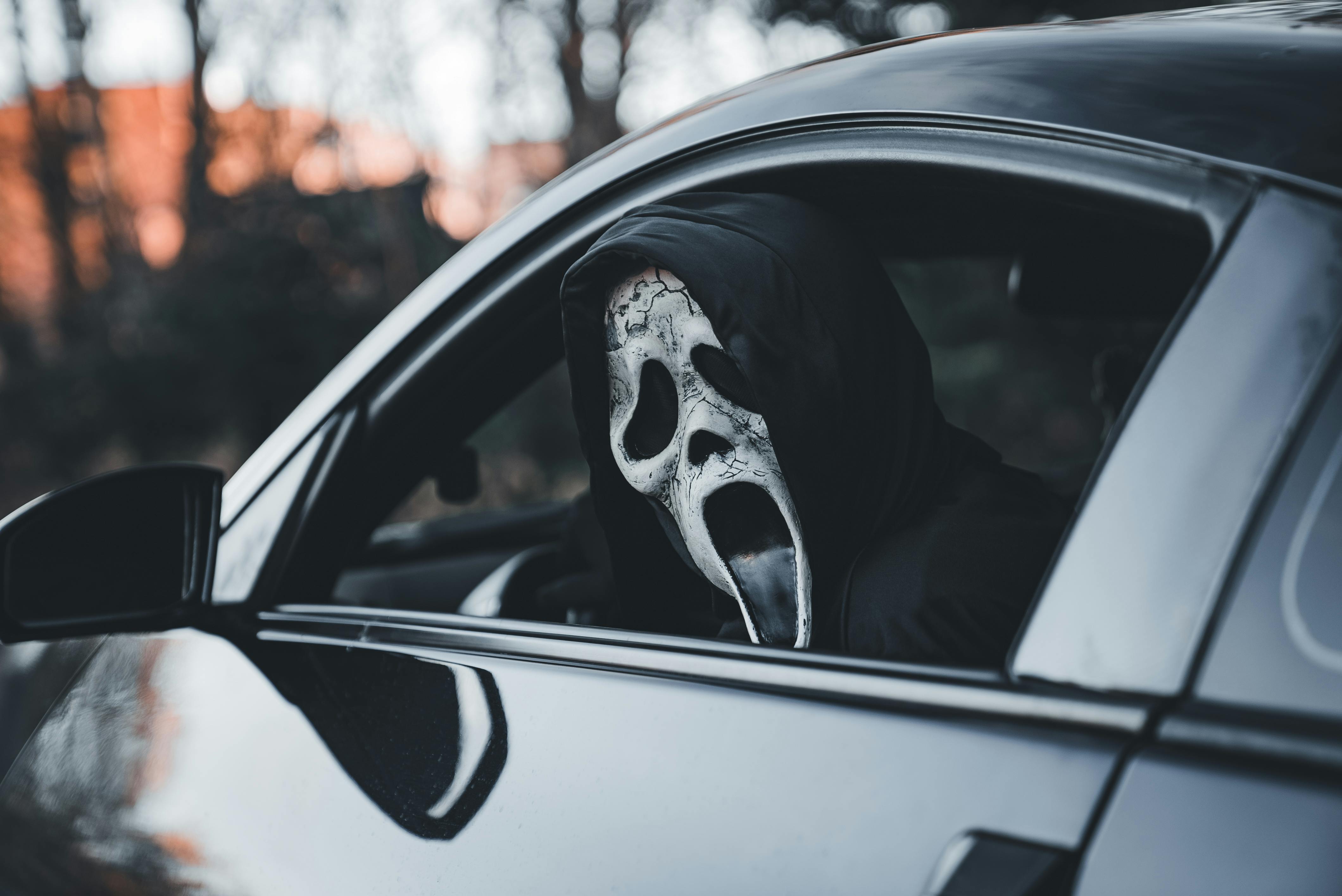 Mysterious Figure in Car with Scream Mask · Free Stock Photo