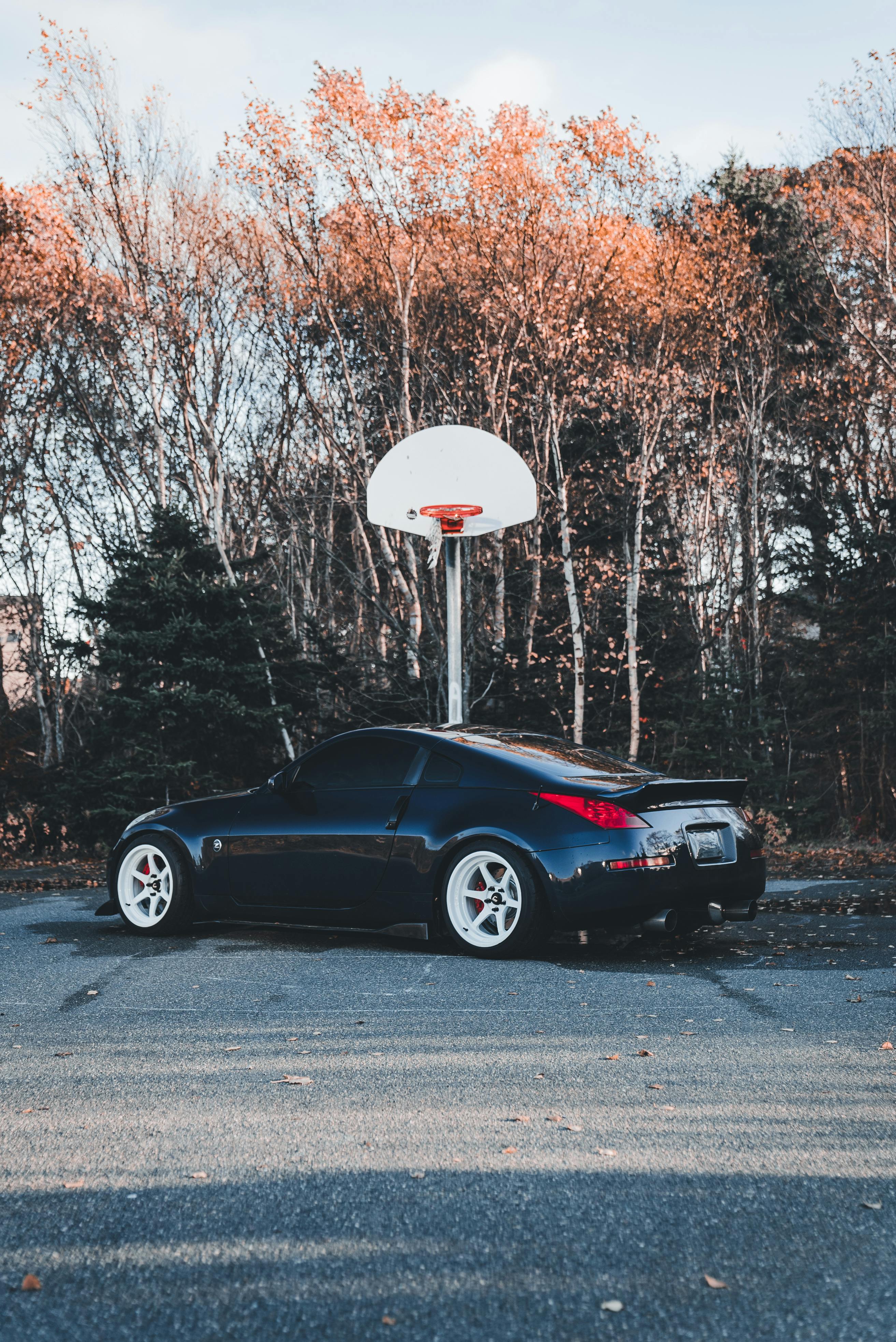 Black Sports Car in Autumn Urban Setting · Free Stock Photo