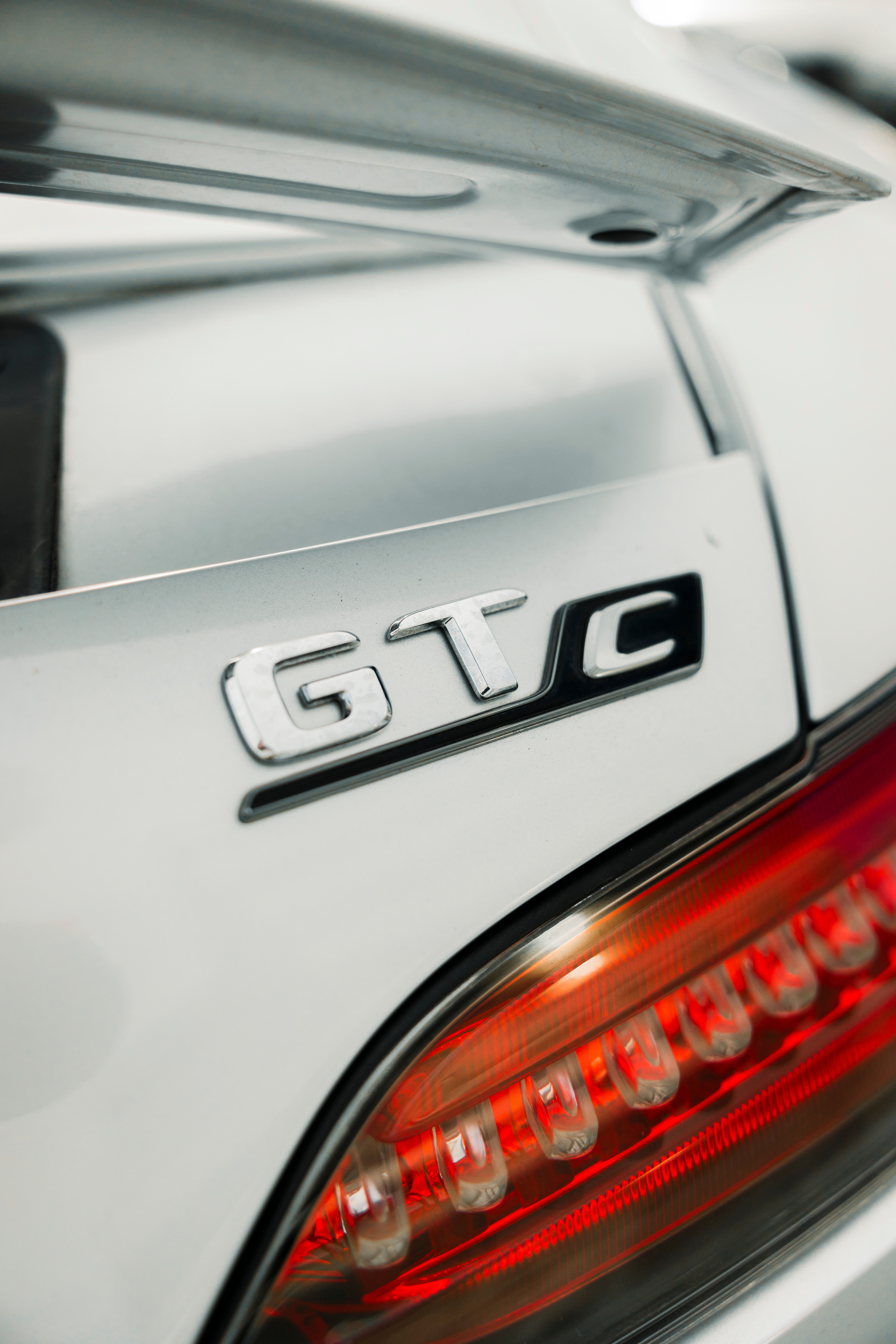 Close-up of GTC Car Badge on Silver Vehicle · Free Stock Photo