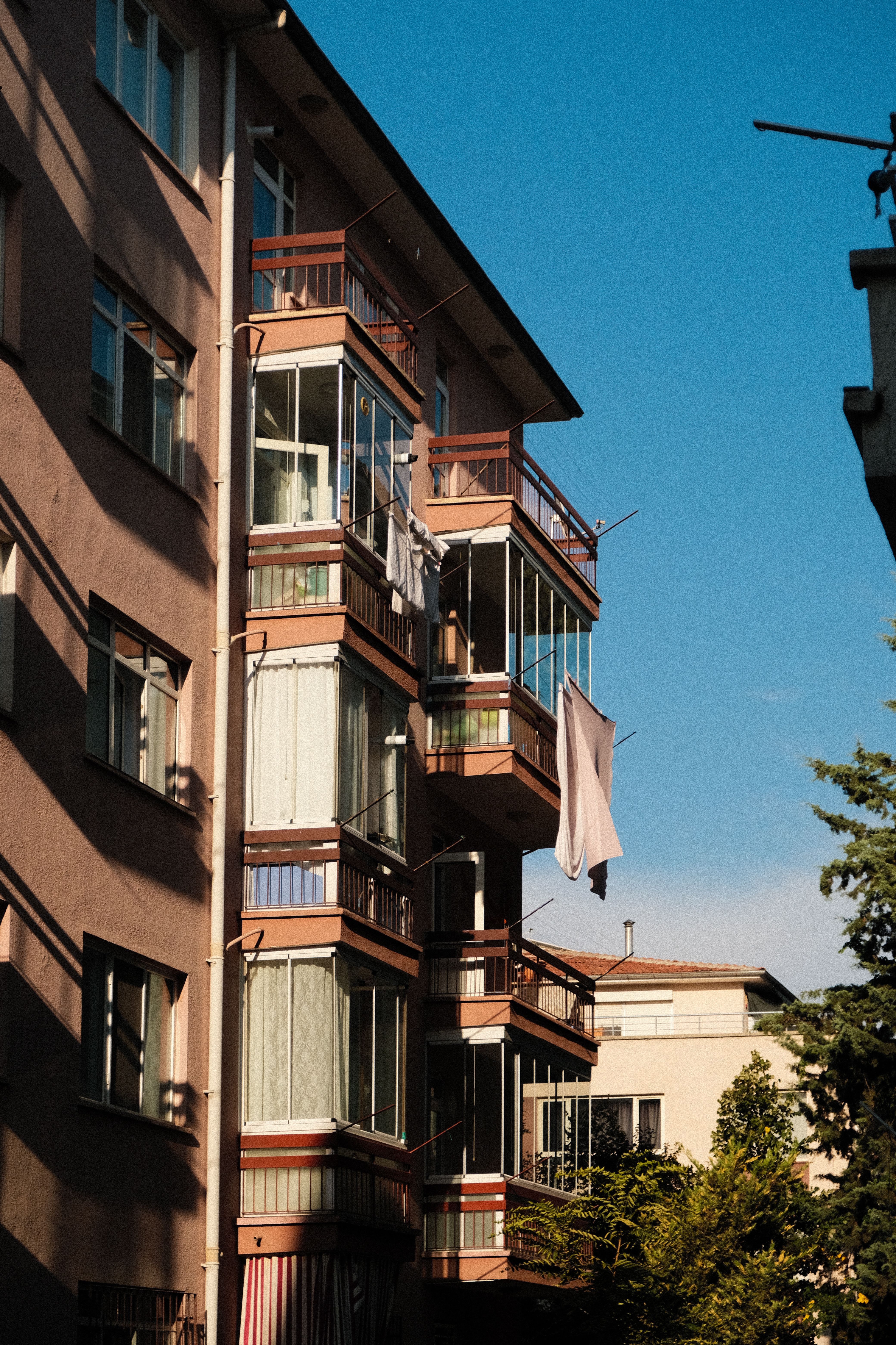 Sunlit Apartment Building Facade Exterior View · Free Stock Photo
