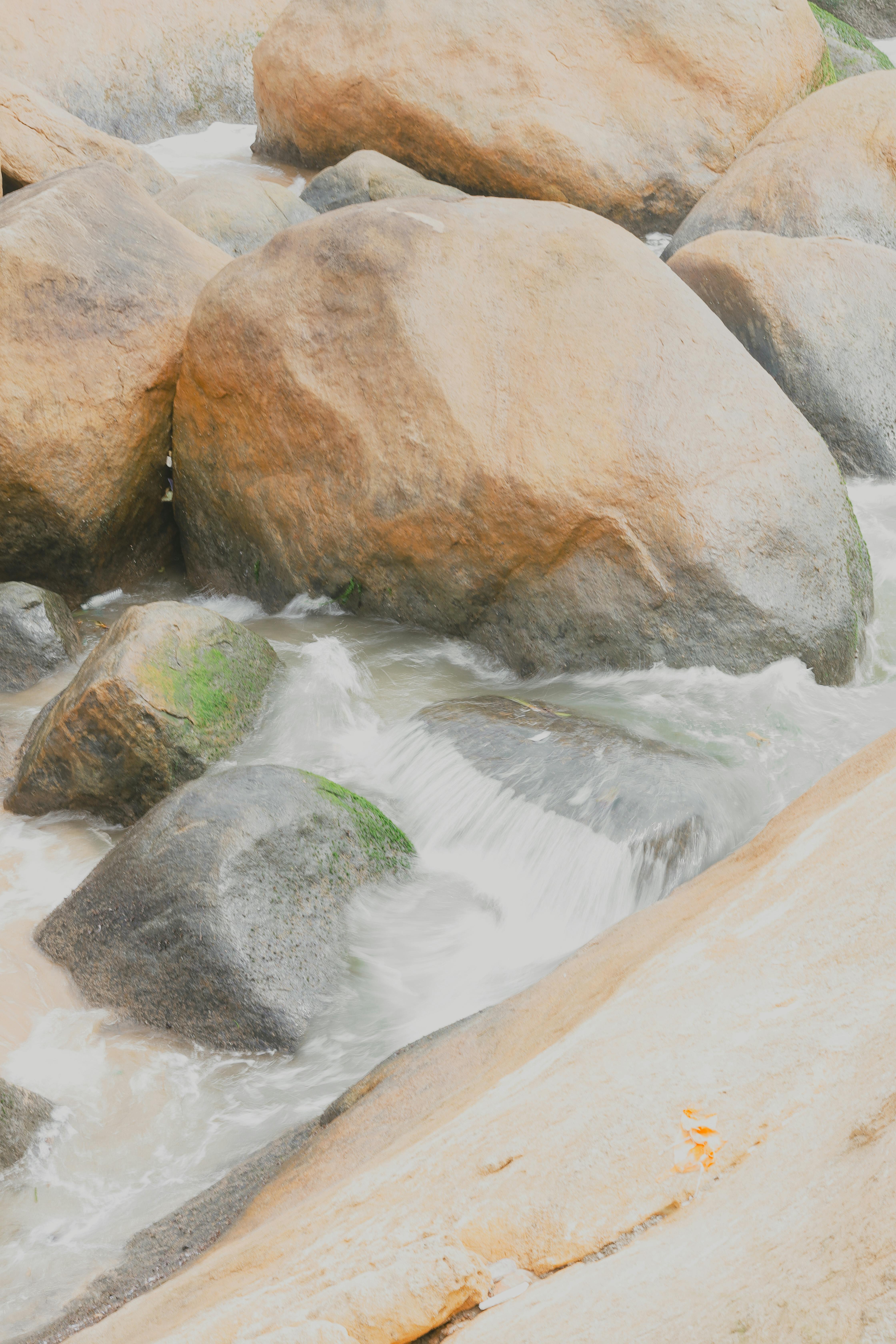 Peaceful Flowing Stream Through Smooth Boulder · Free Stock Photo