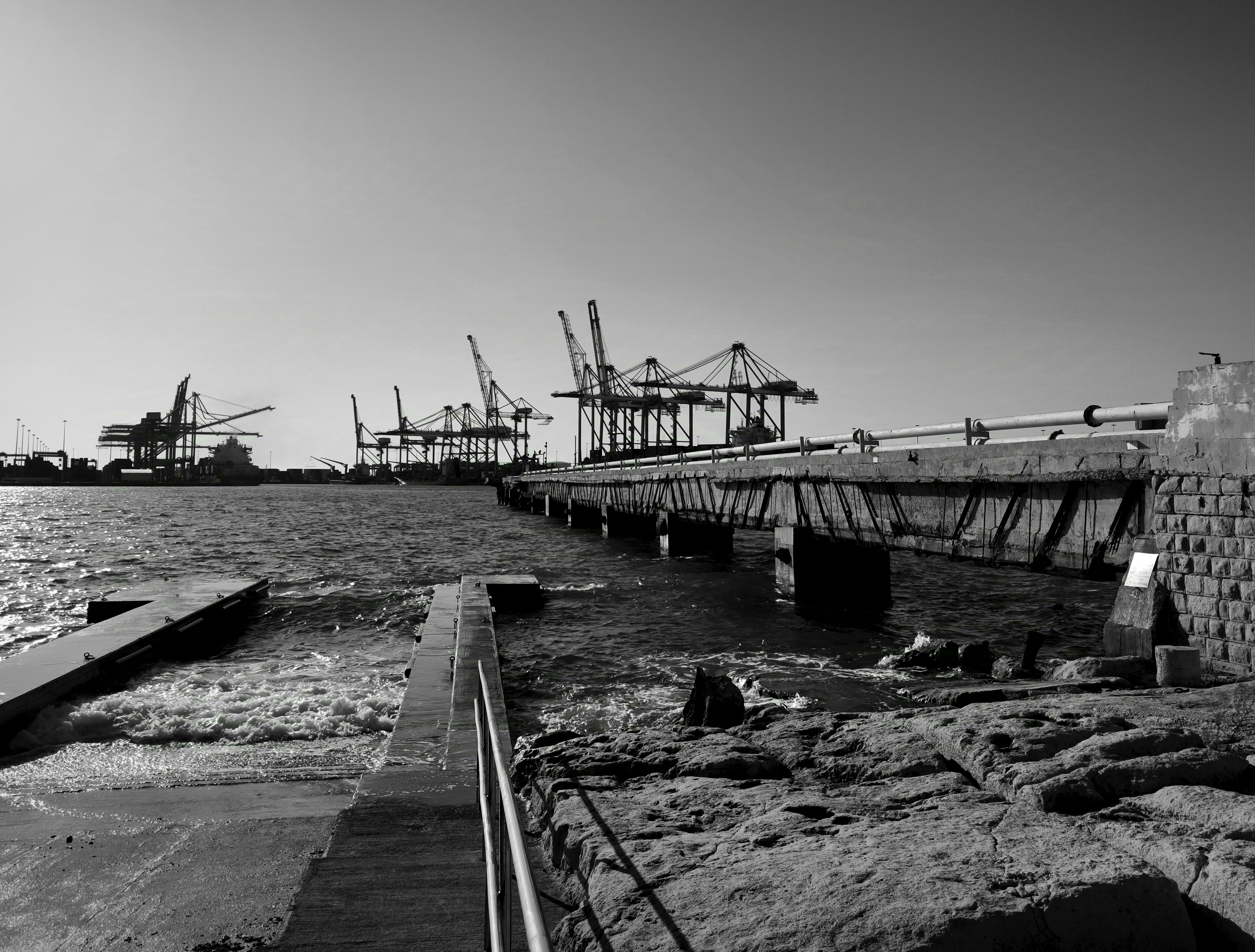 Industrial Seaside Docks with Cranes in Black and White · Free Stock Photo