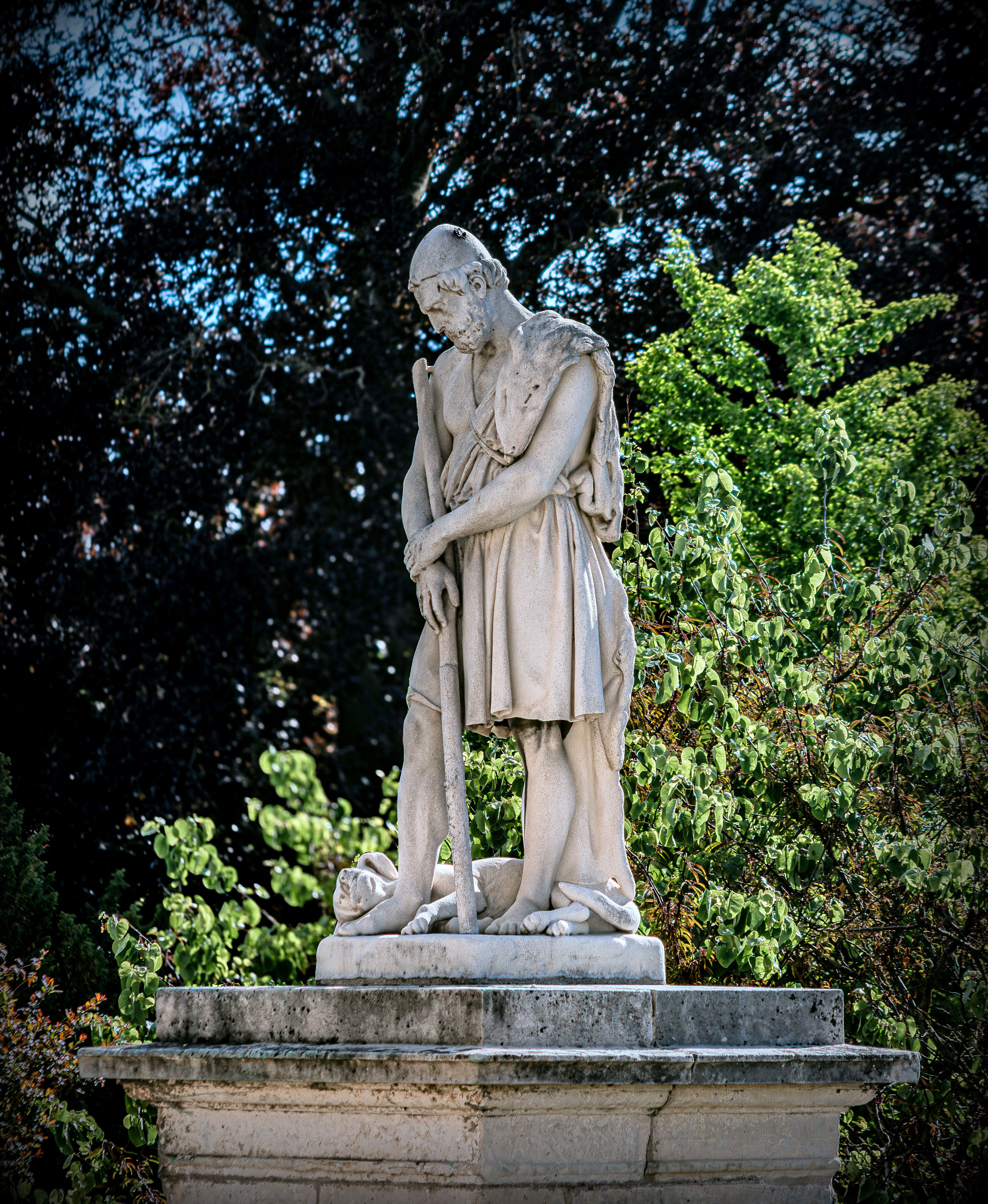 Ancient Roman Statue in Verdant Park Setting · Free Stock Photo