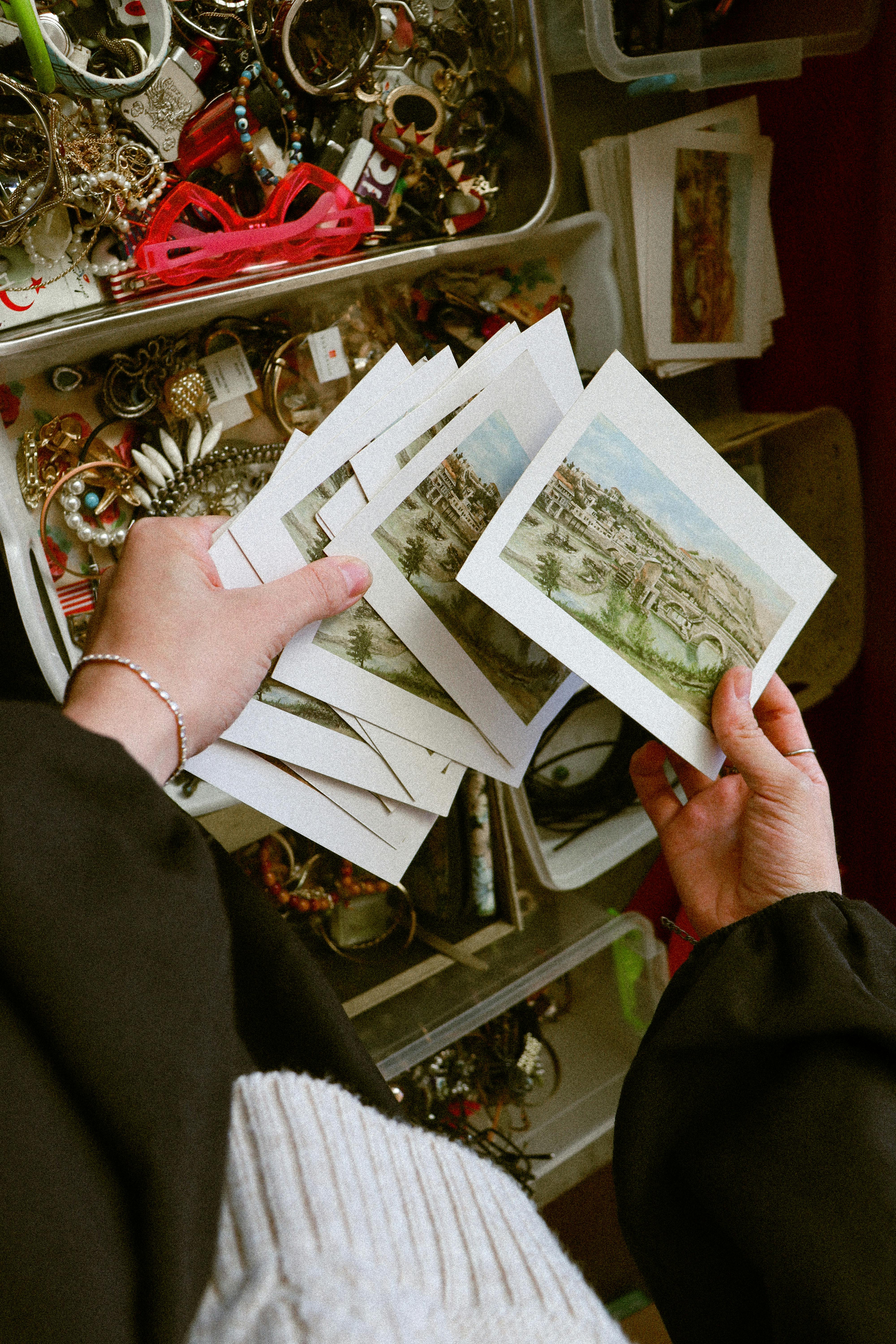 Person Sorting Vintage Postcards in Antique Shop · Free Stock Photo