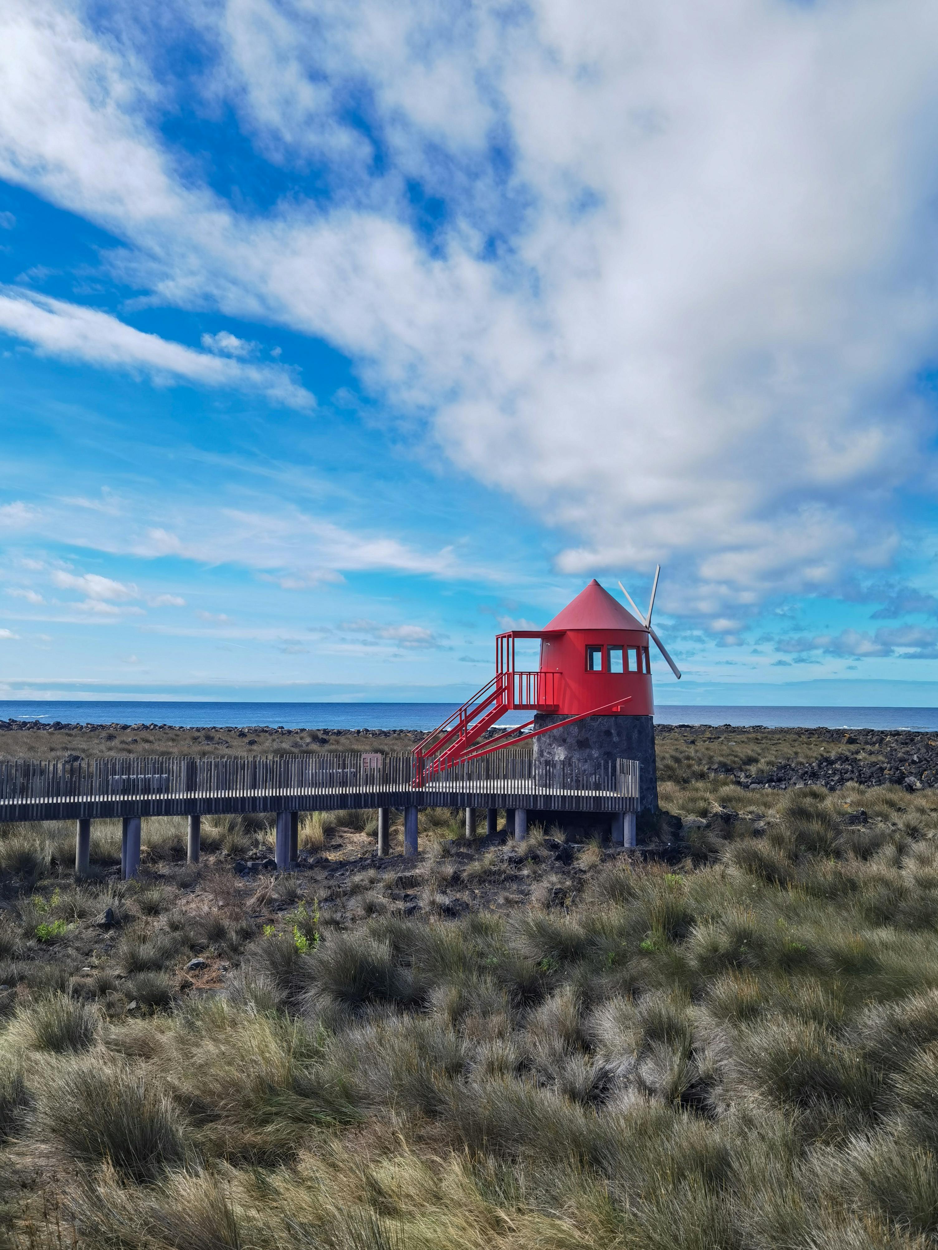 Red Windmill by the Sea with Wooden Pathway · Free Stock Photo