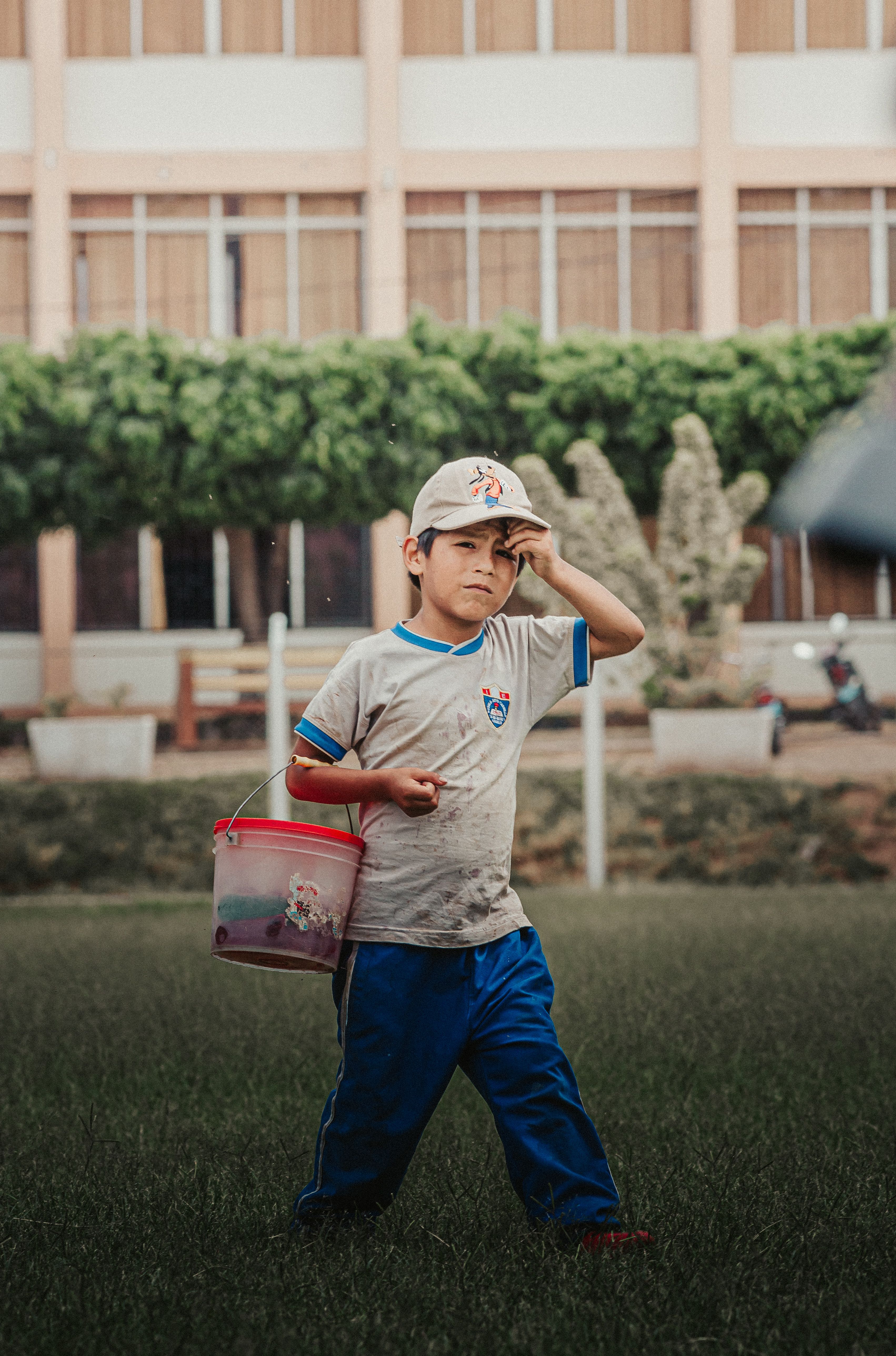 Young Boy Walking with Bucket Outdoors · Free Stock Photo