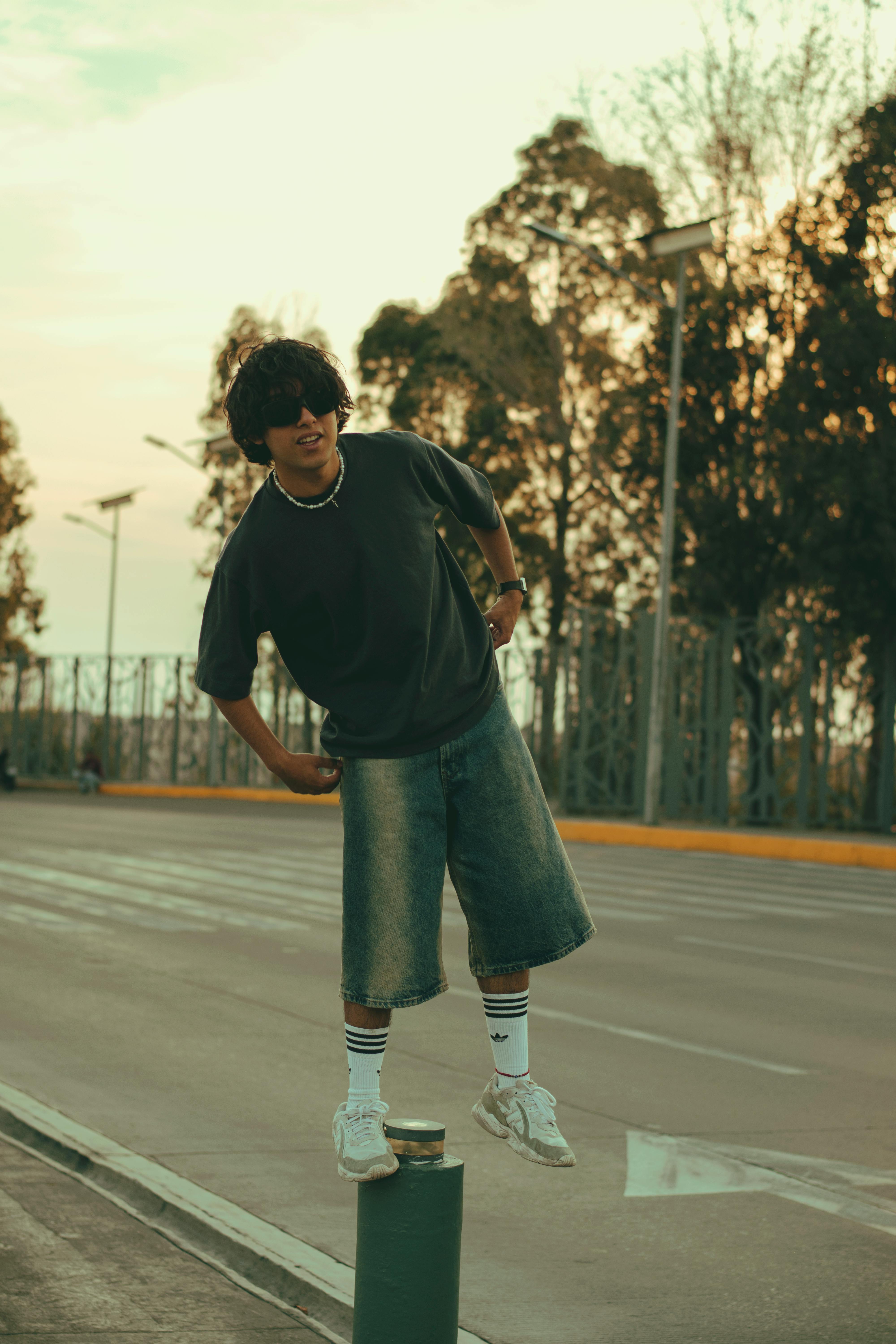 Young Man Balancing on Urban Post at Sunset · Free Stock Photo