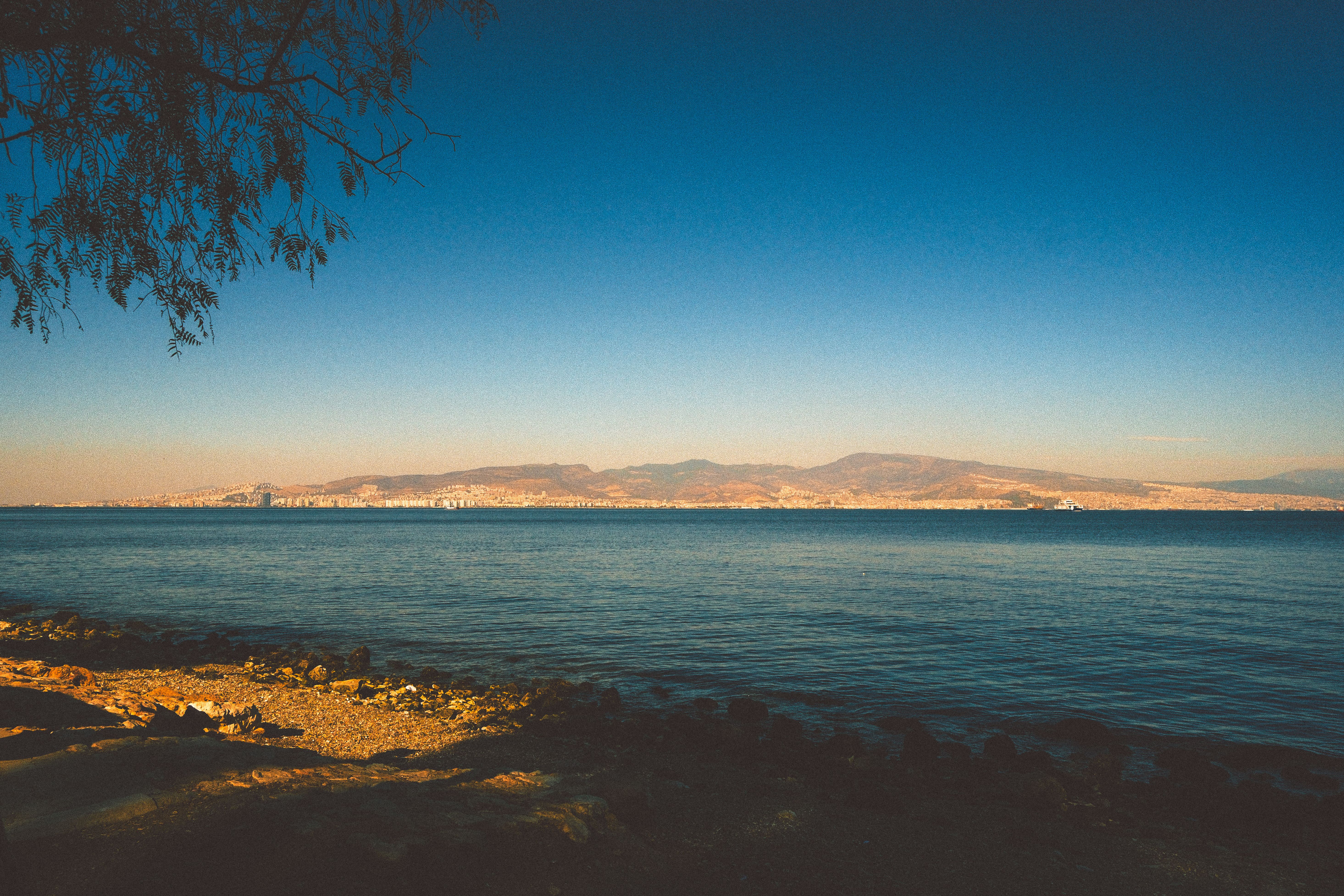 Beautiful Ocean View with Distant Hills at Sunset · Free Stock Photo