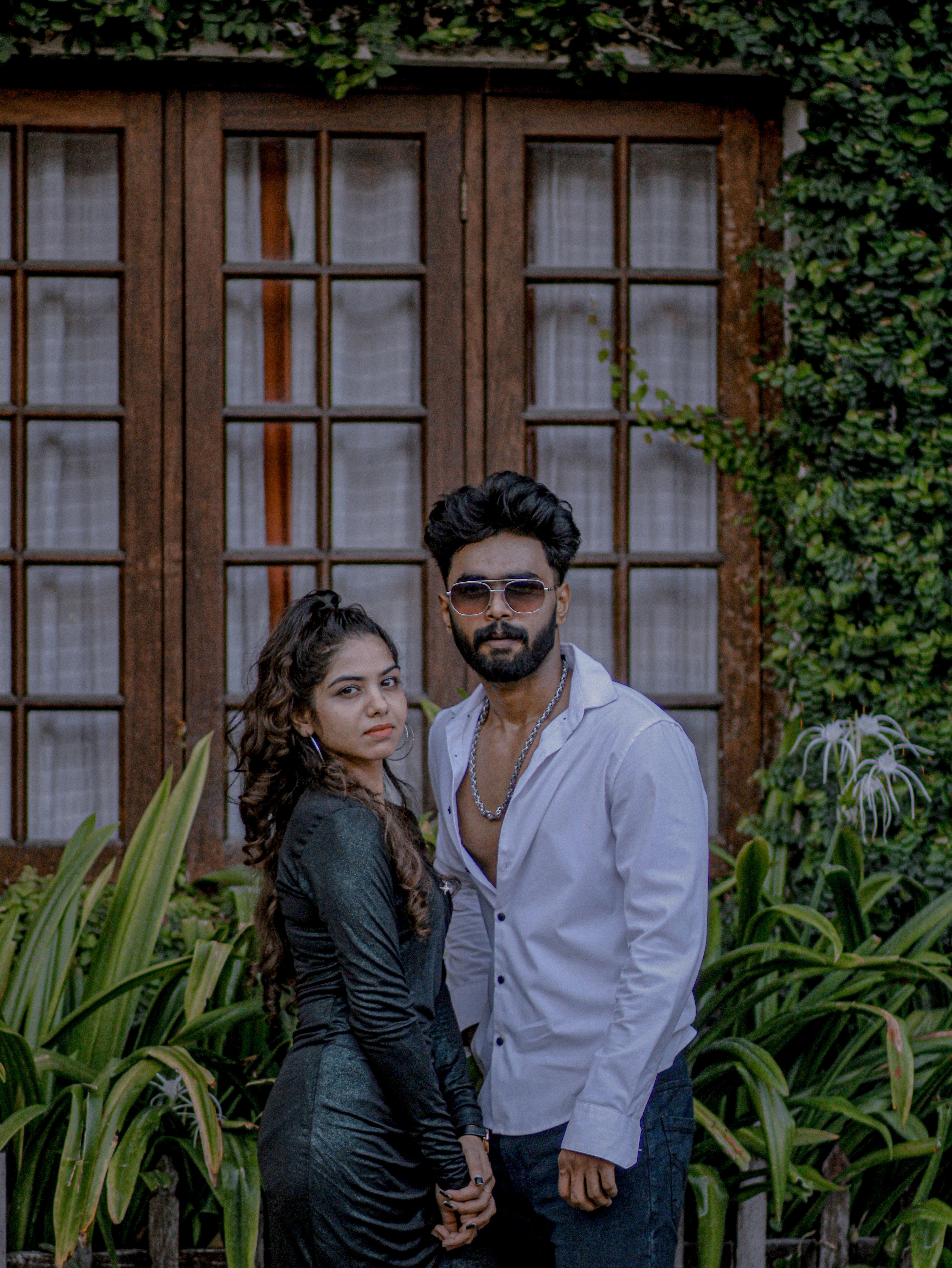 Stylish Couple Posing Outdoors by a Window · Free Stock Photo
