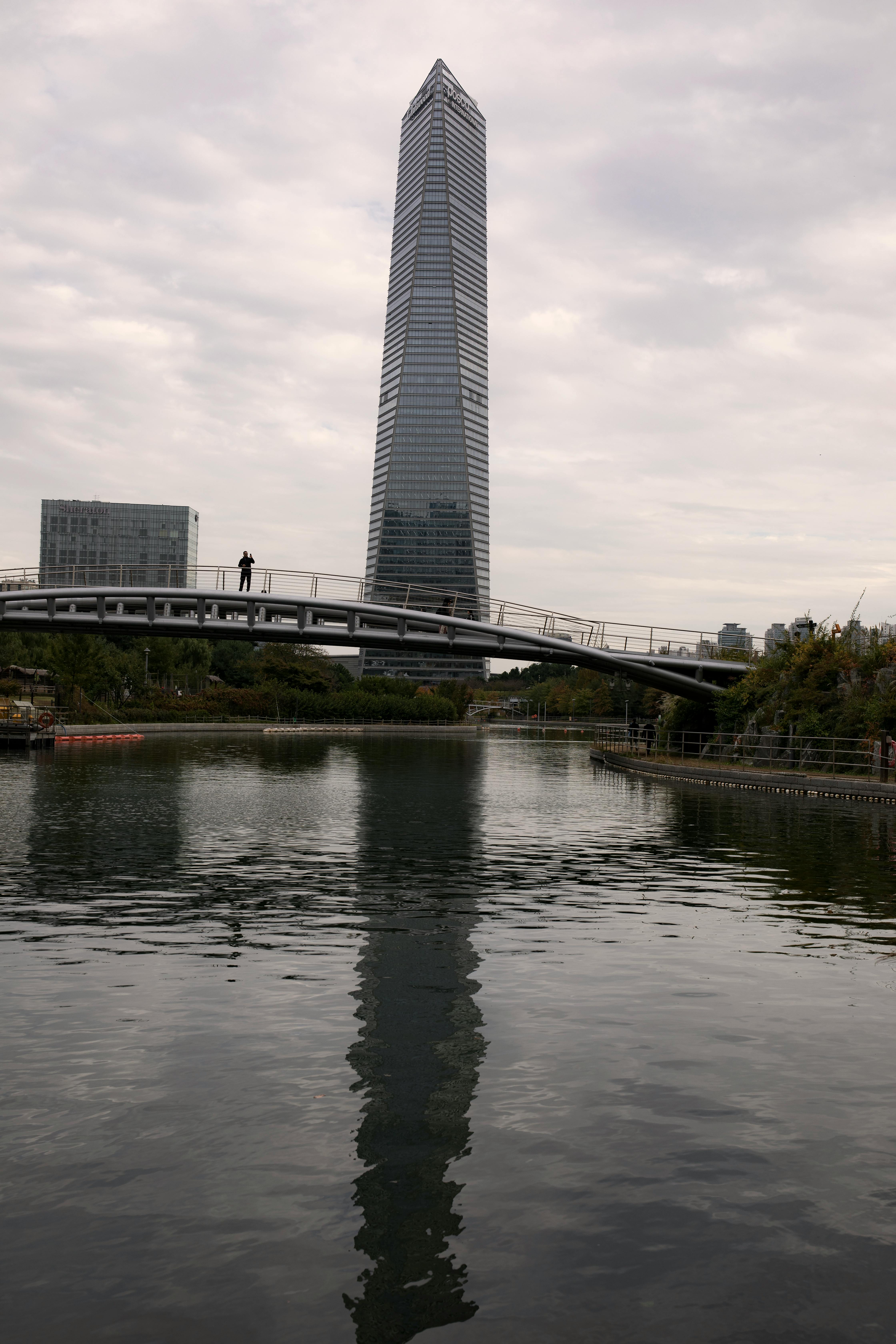 Tall Modern Skyscraper Over Water Bridge · Free Stock Photo