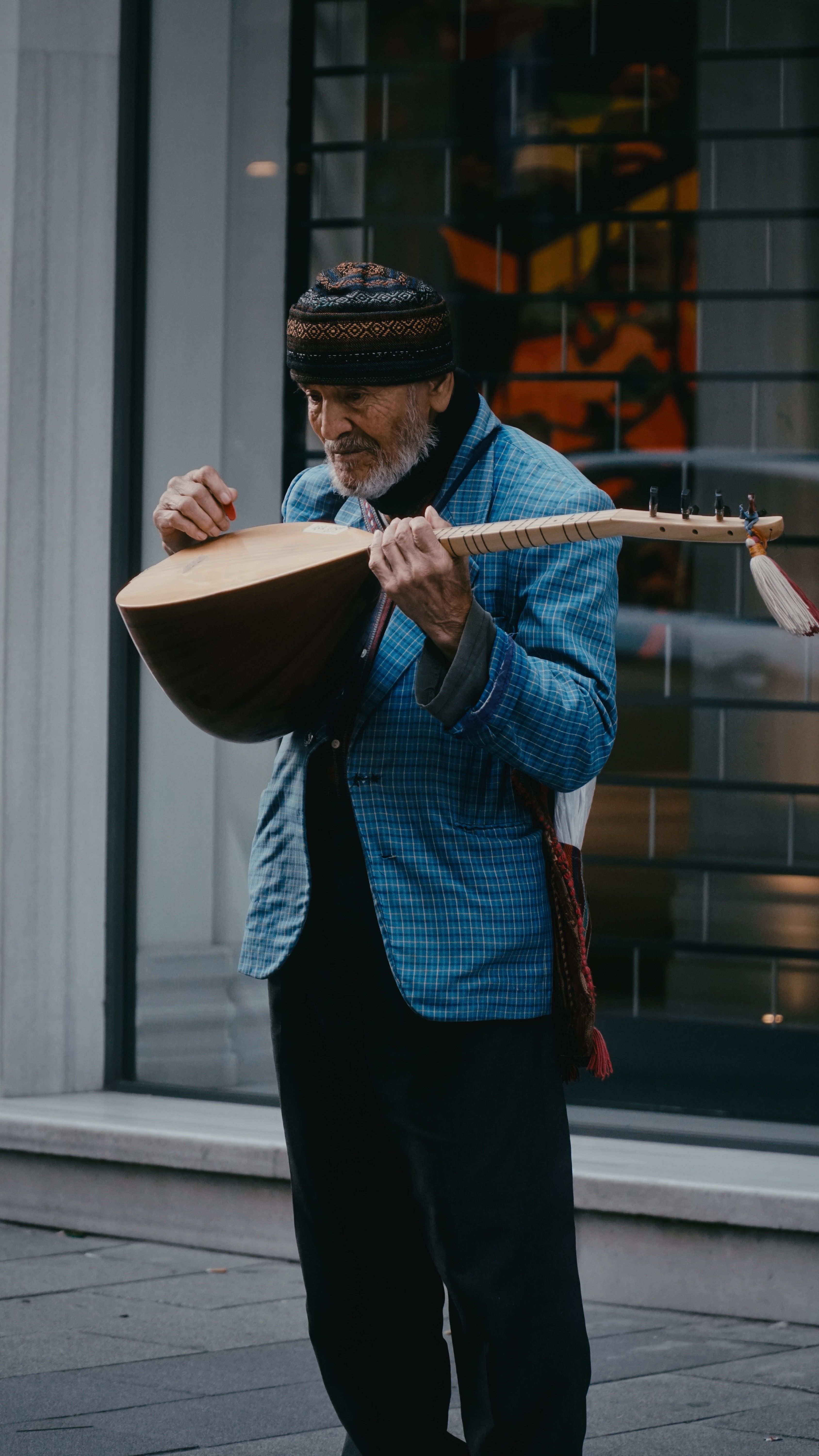 Street Musician Playing Traditional Instrument Outdoors · Free Stock Photo