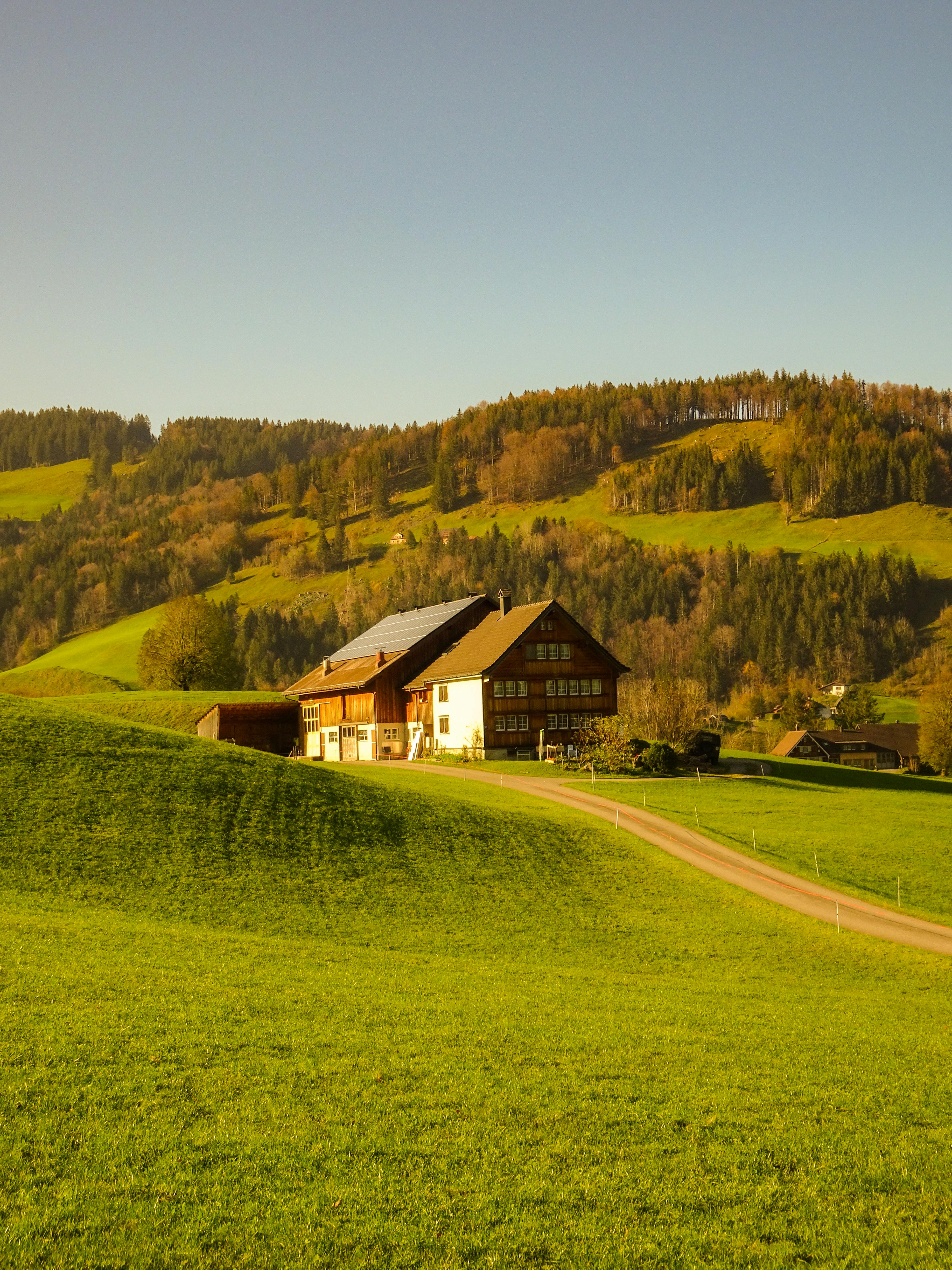 Swiss Countryside House Surrounded by Lush Green Hills · Free Stock Photo