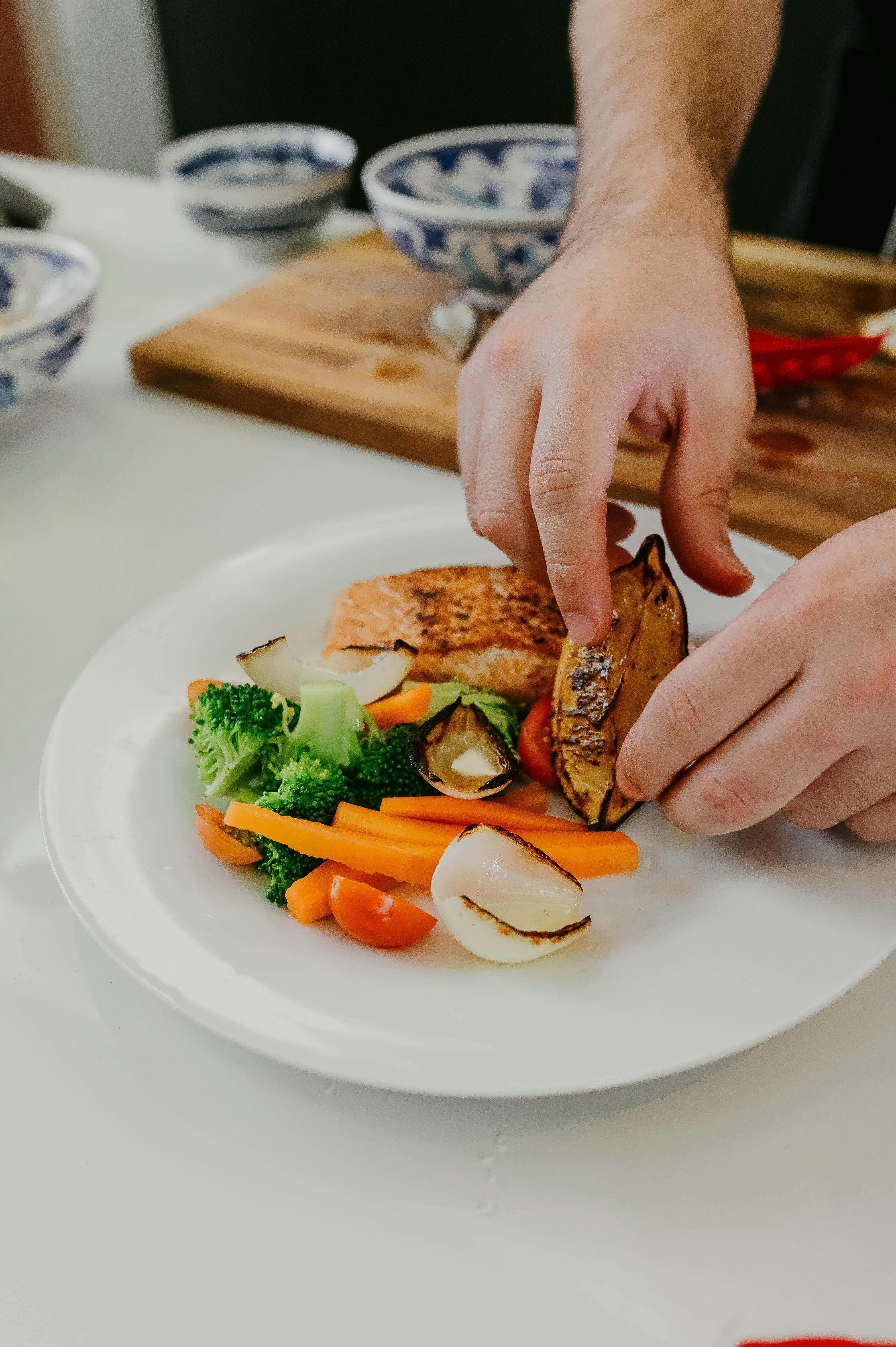Chef Plating Grilled Salmon and Vegetables · Free Stock Photo