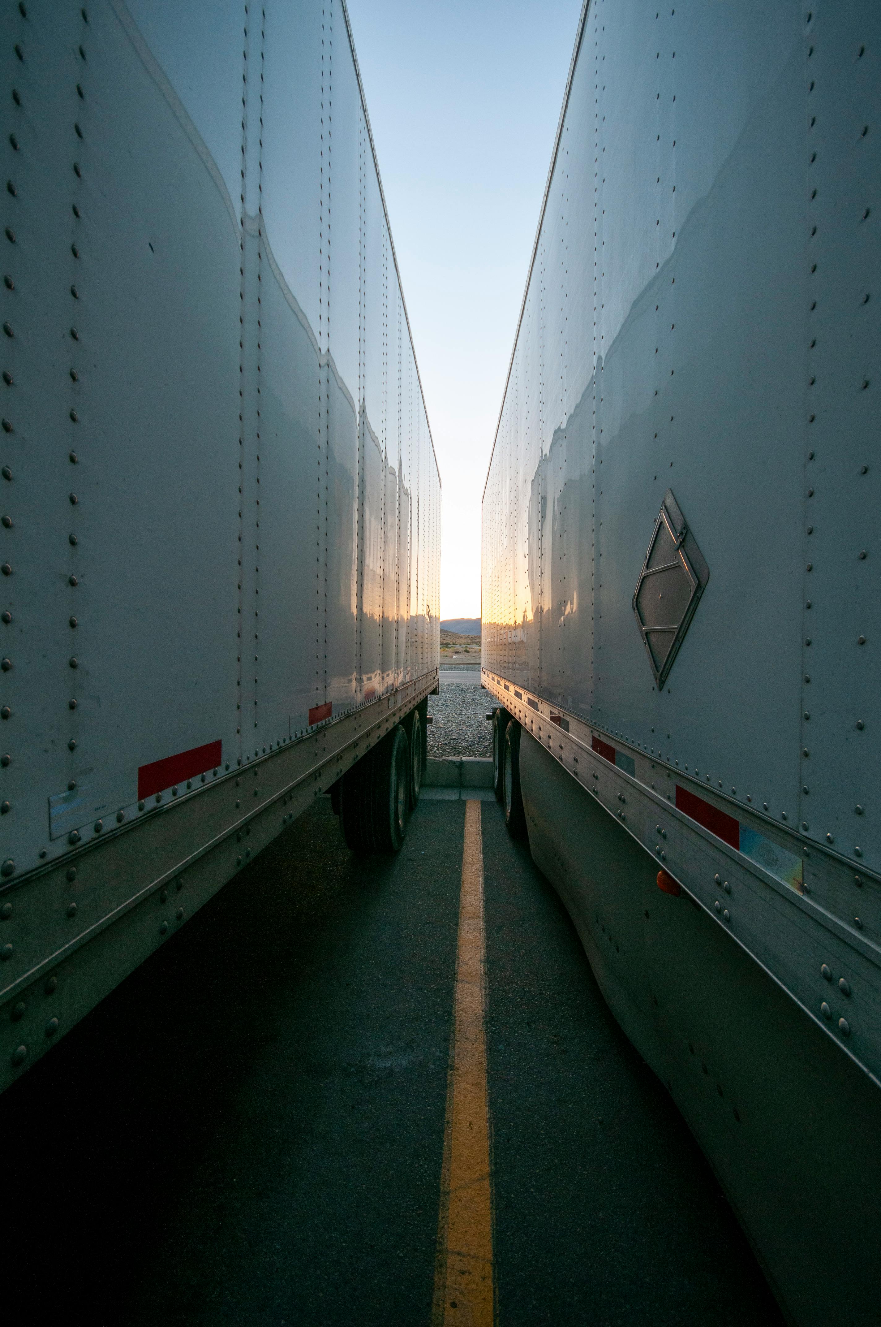 Symmetrical View Between Two Trucks at Sunset · Free Stock Photo