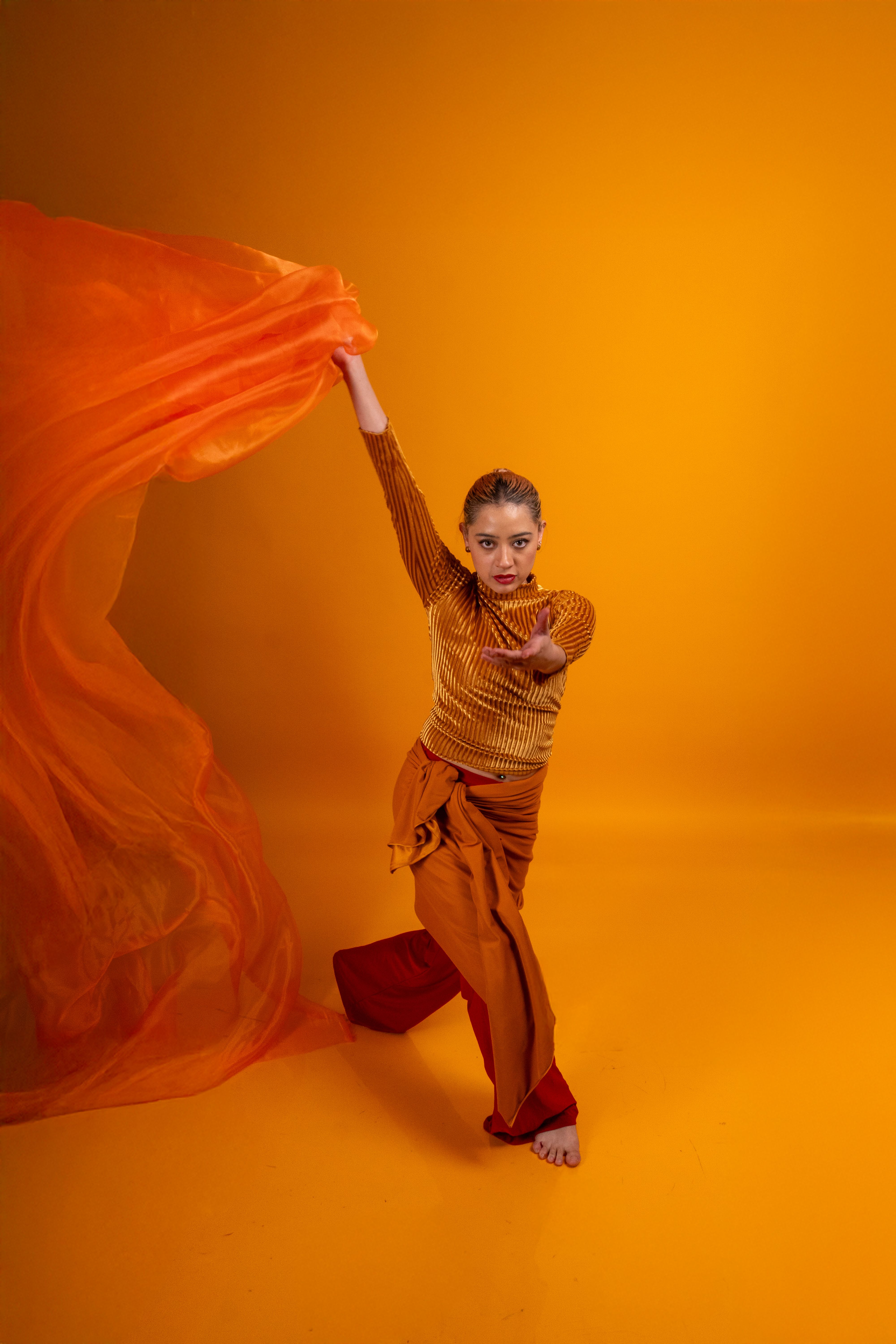 Elegant Female Dancer in Flowing Orange Attire · Free Stock Photo