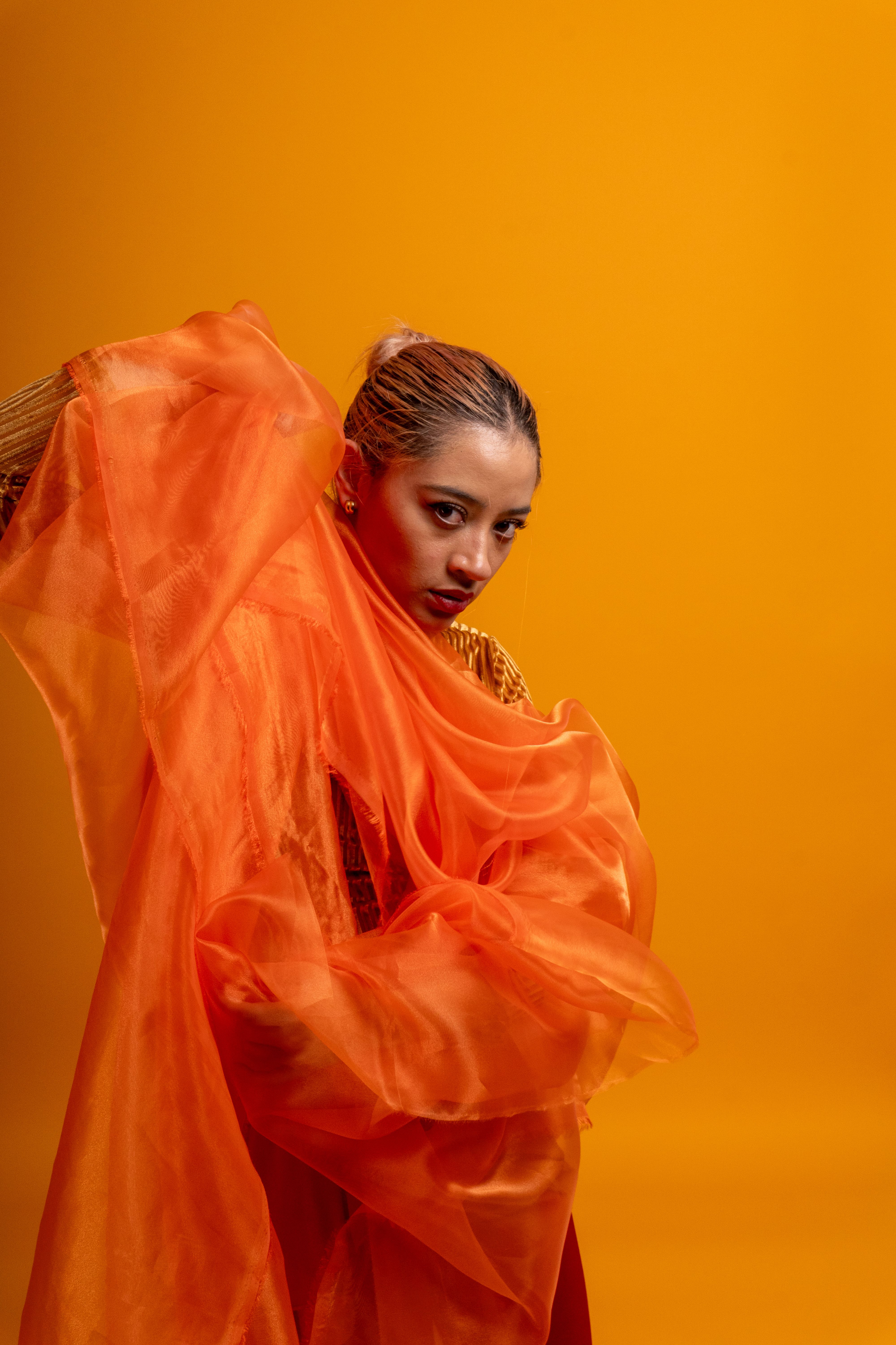 Dynamic Female Dancer in Vibrant Orange Fabric · Free Stock Photo