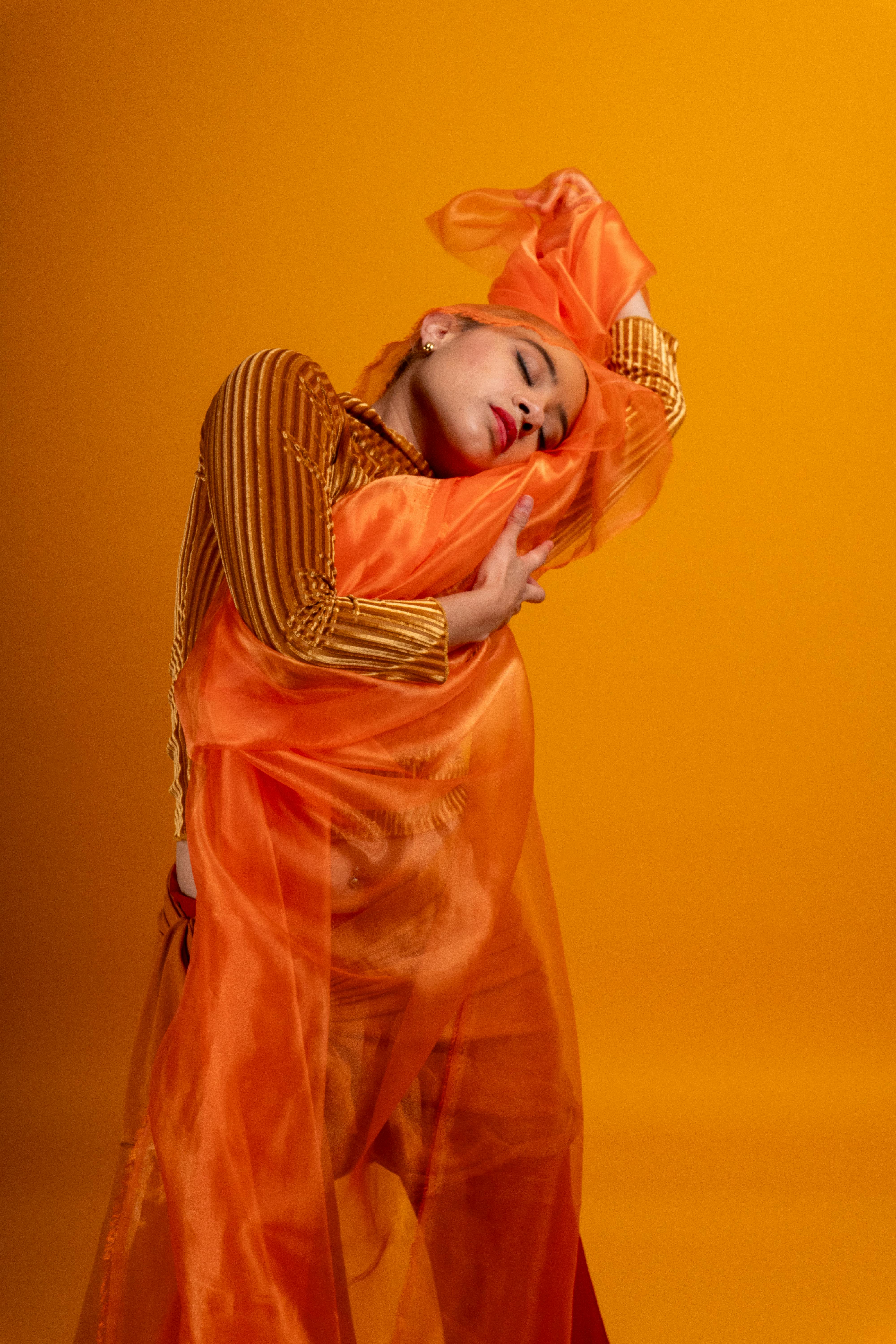 Graceful Dance in Vibrant Orange Fabric · Free Stock Photo