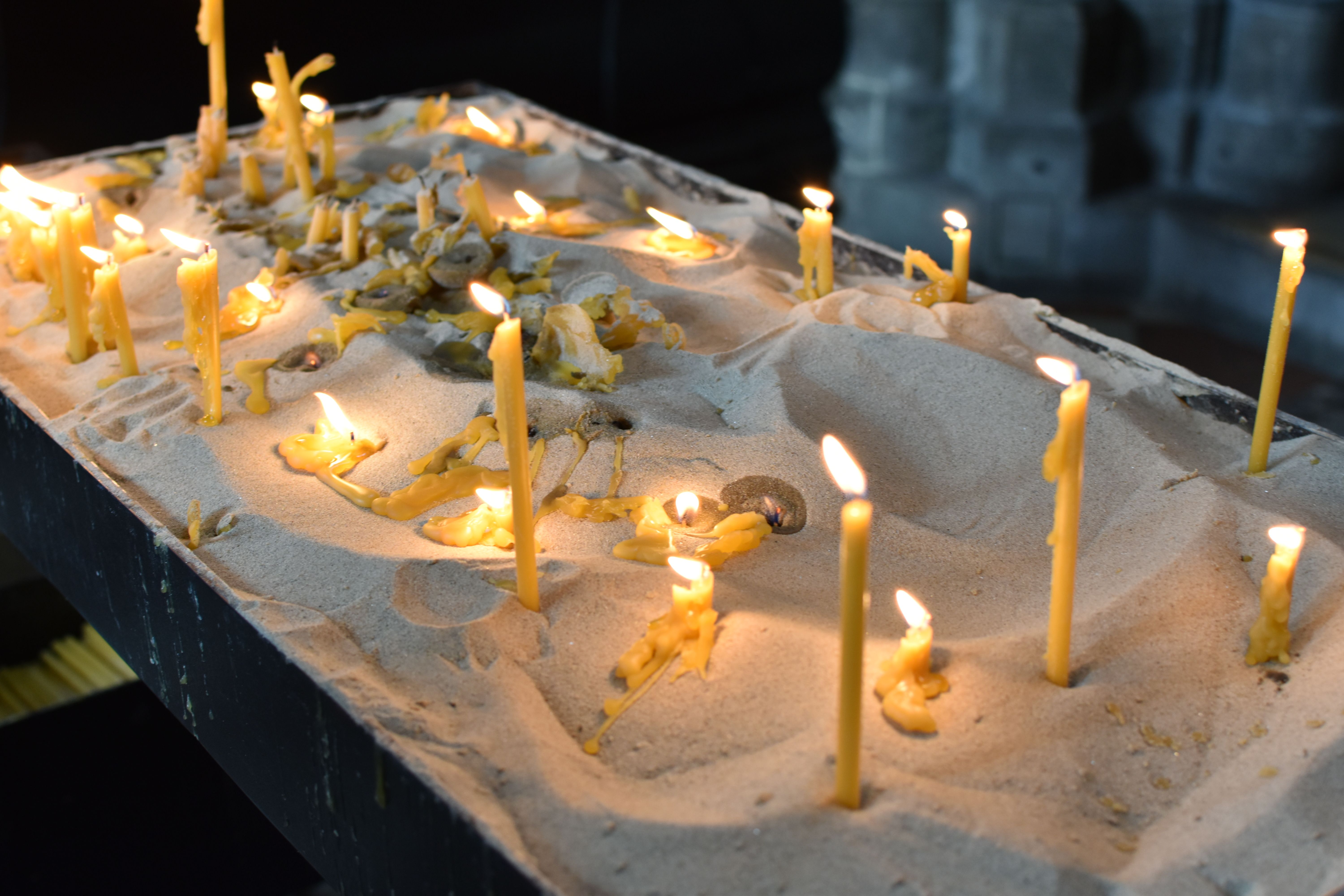 Lit Candles in Sand at a Religious Altar · Free Stock Photo
