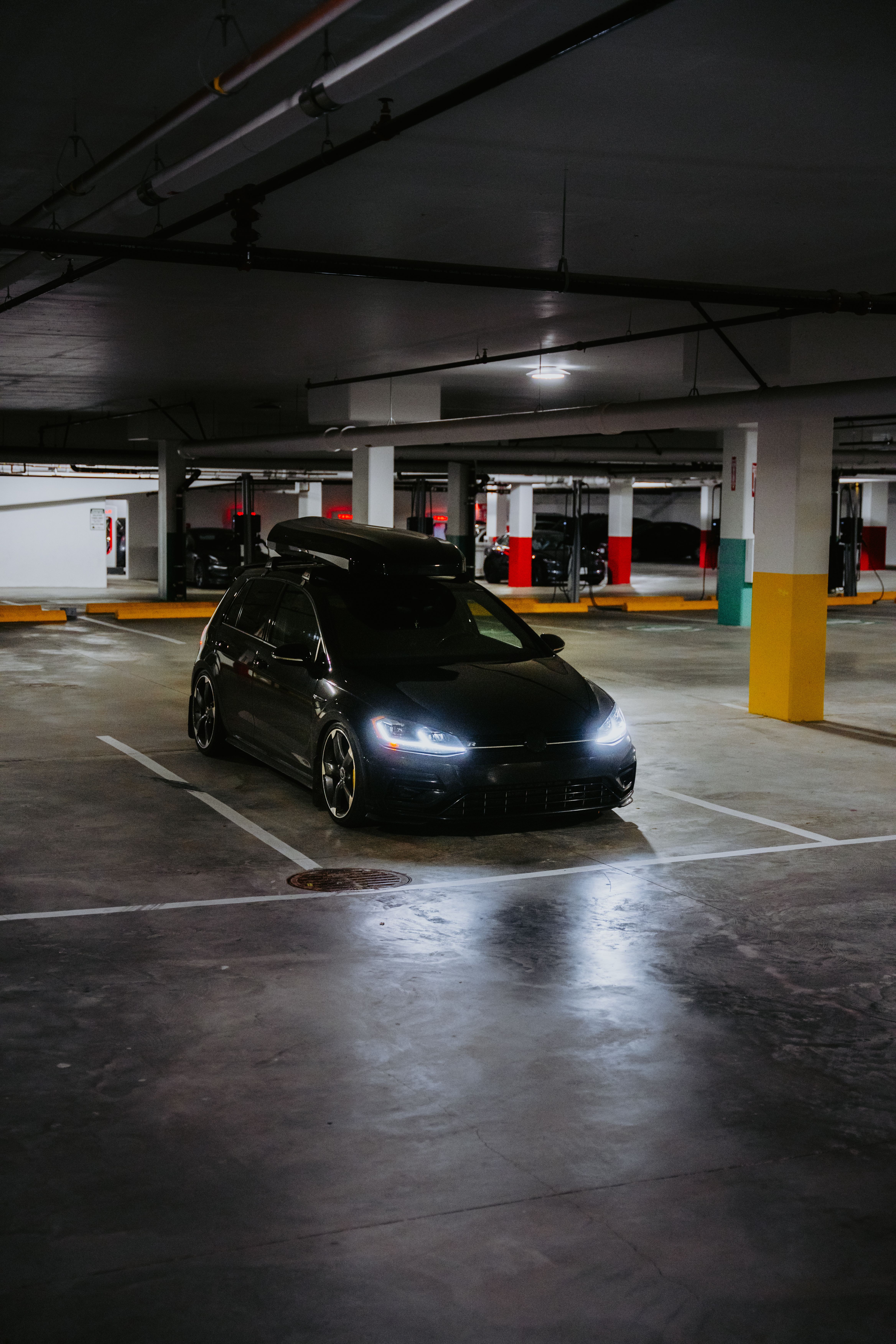 Sleek Black Car in Dimly Lit Parking Garage · Free Stock Photo