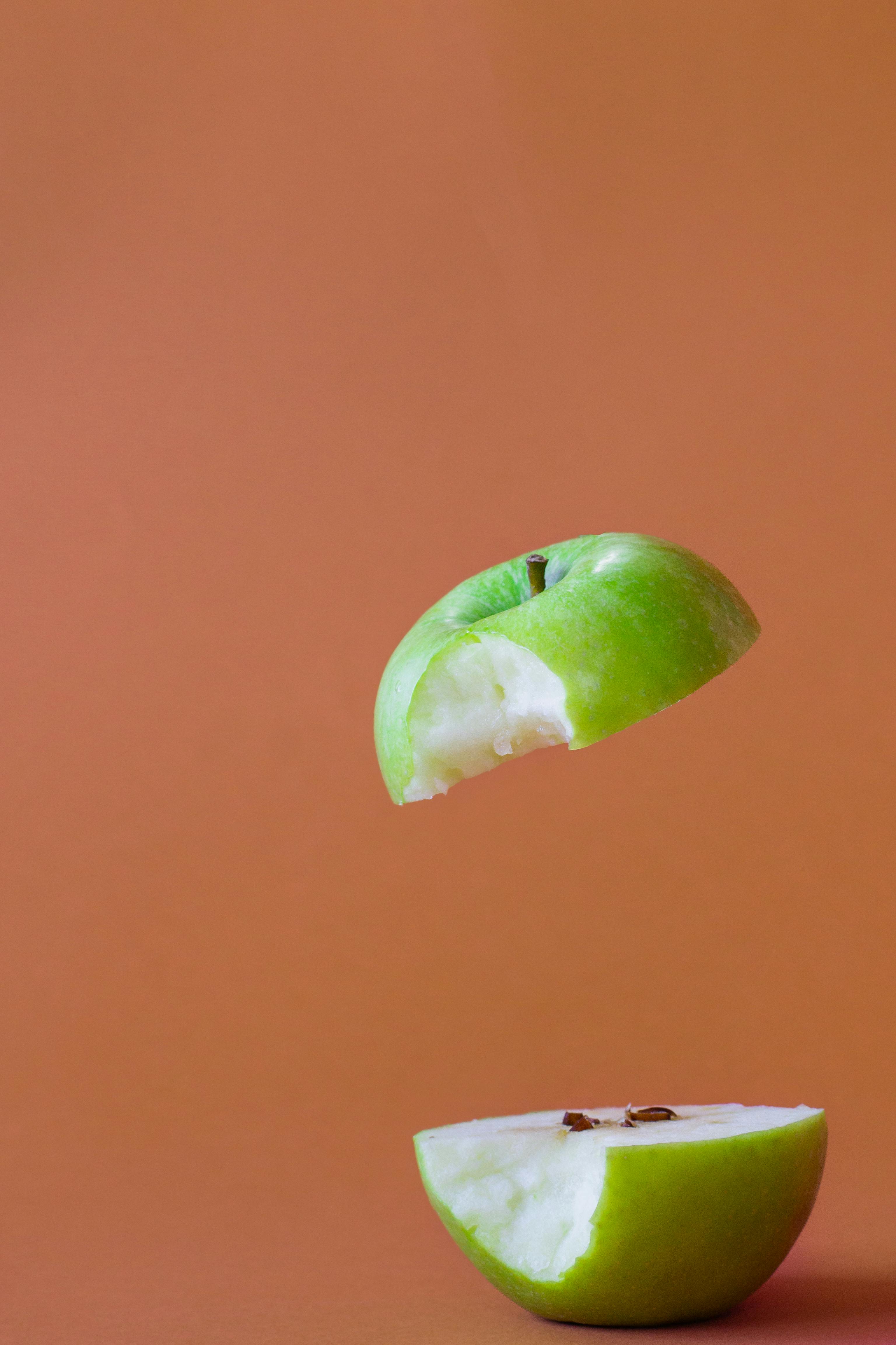 Floating Green Apple Slices with Orange Background · Free Stock Photo