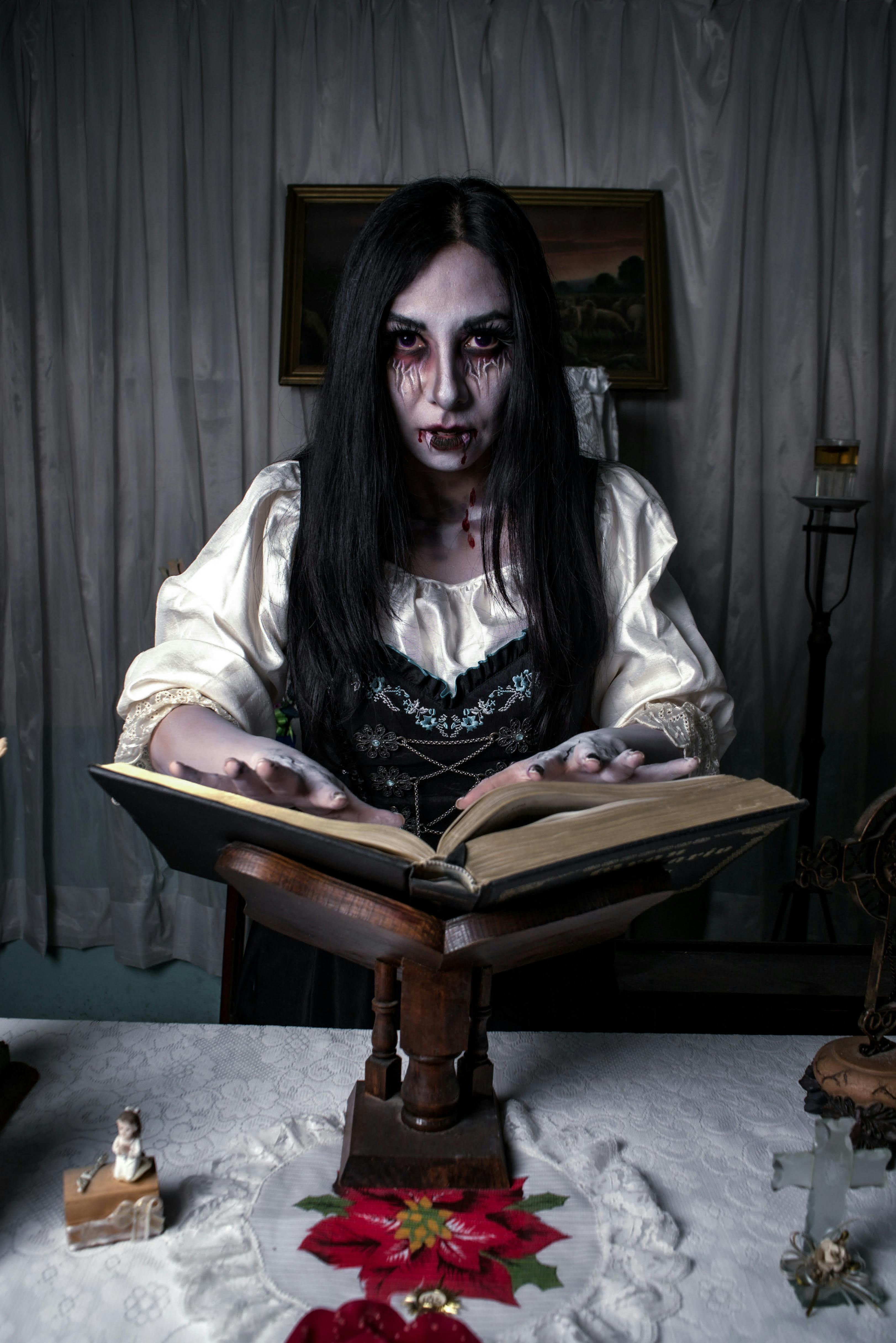 Gothic Woman Reading Spellbook in Candlelit Room · Free Stock Photo