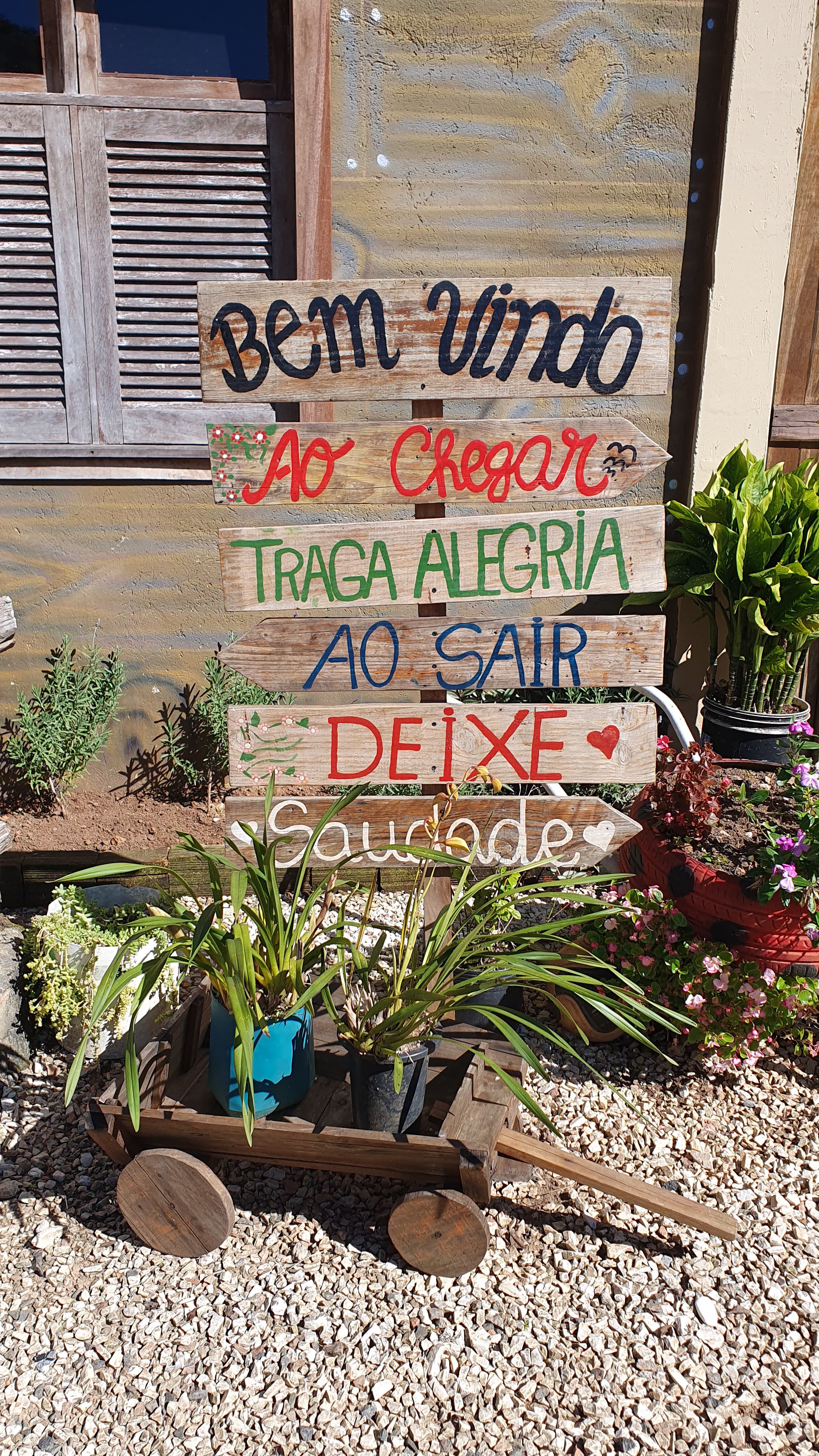 Rustic Welcome Sign with Plants on Sunny Day · Free Stock Photo