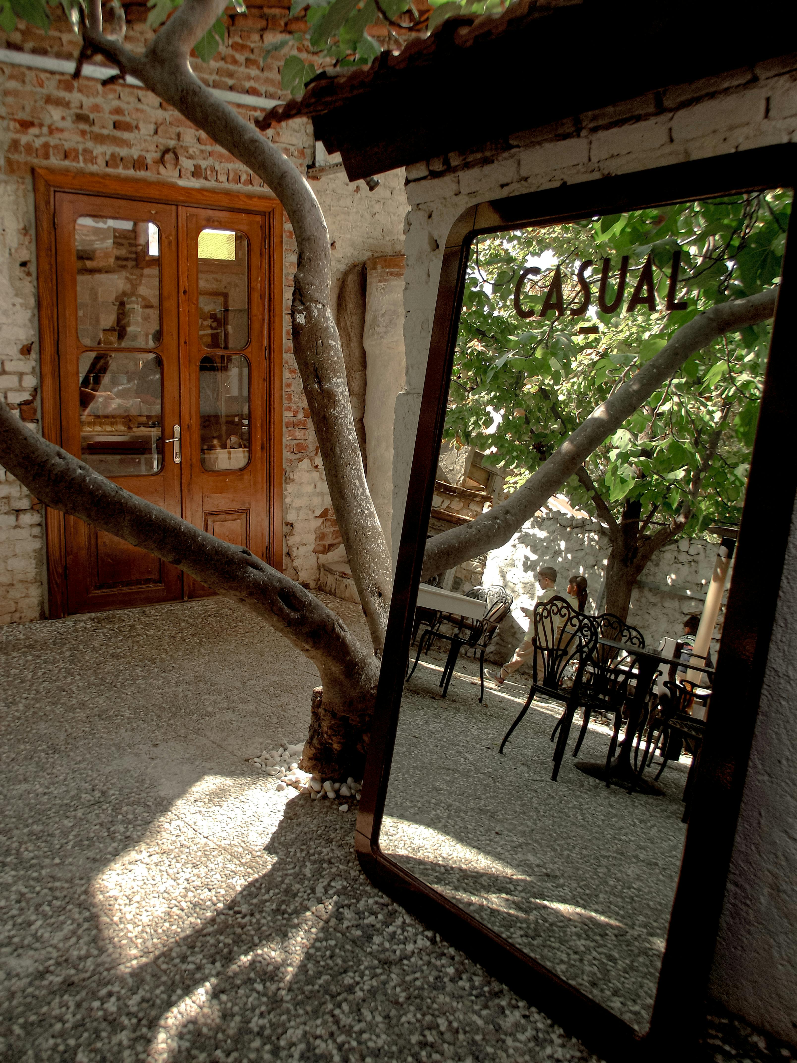 Rustic Outdoor Cafe with Mirror Reflection · Free Stock Photo