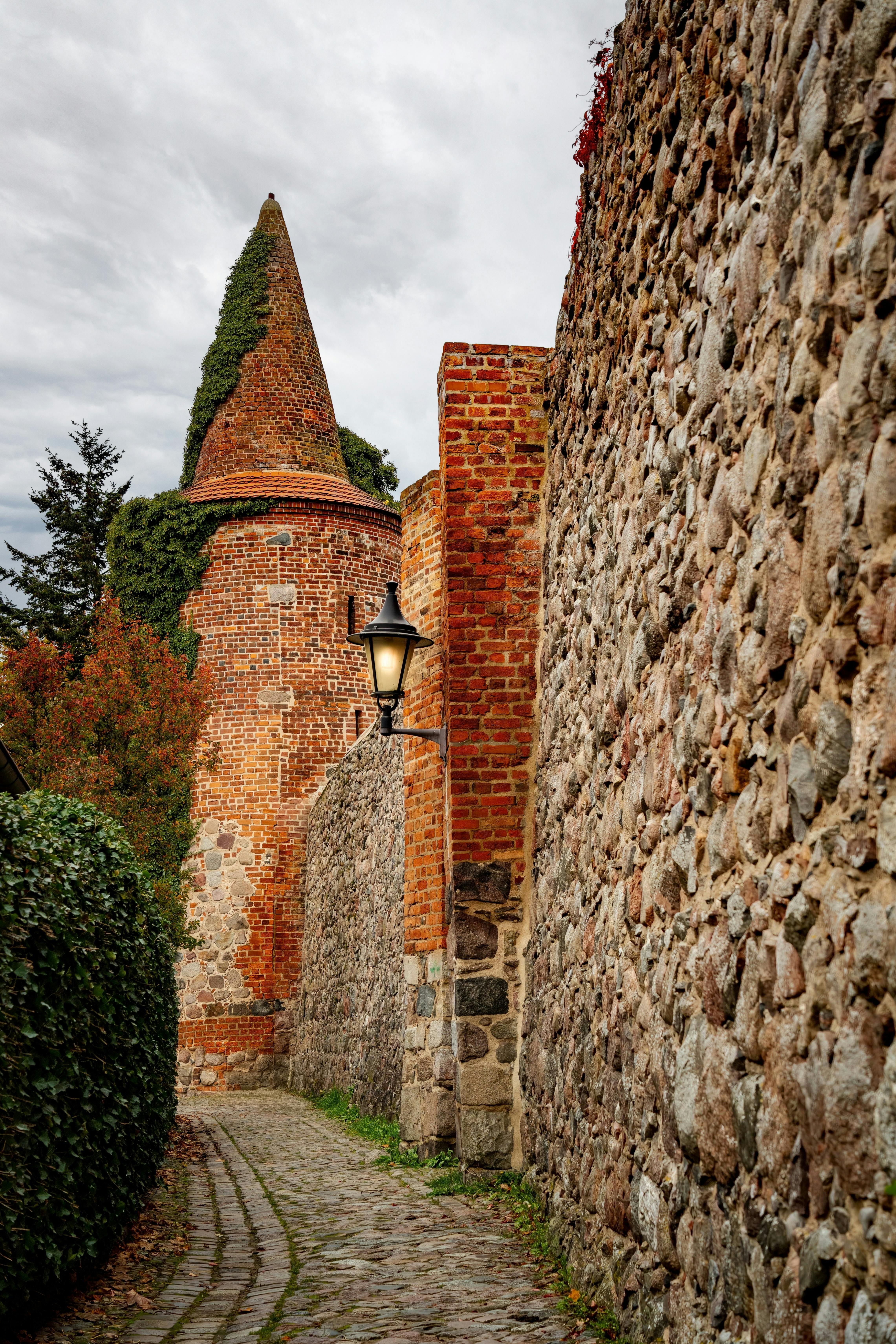 Medieval Brick Tower and Stone Wall Pathway · Free Stock Photo