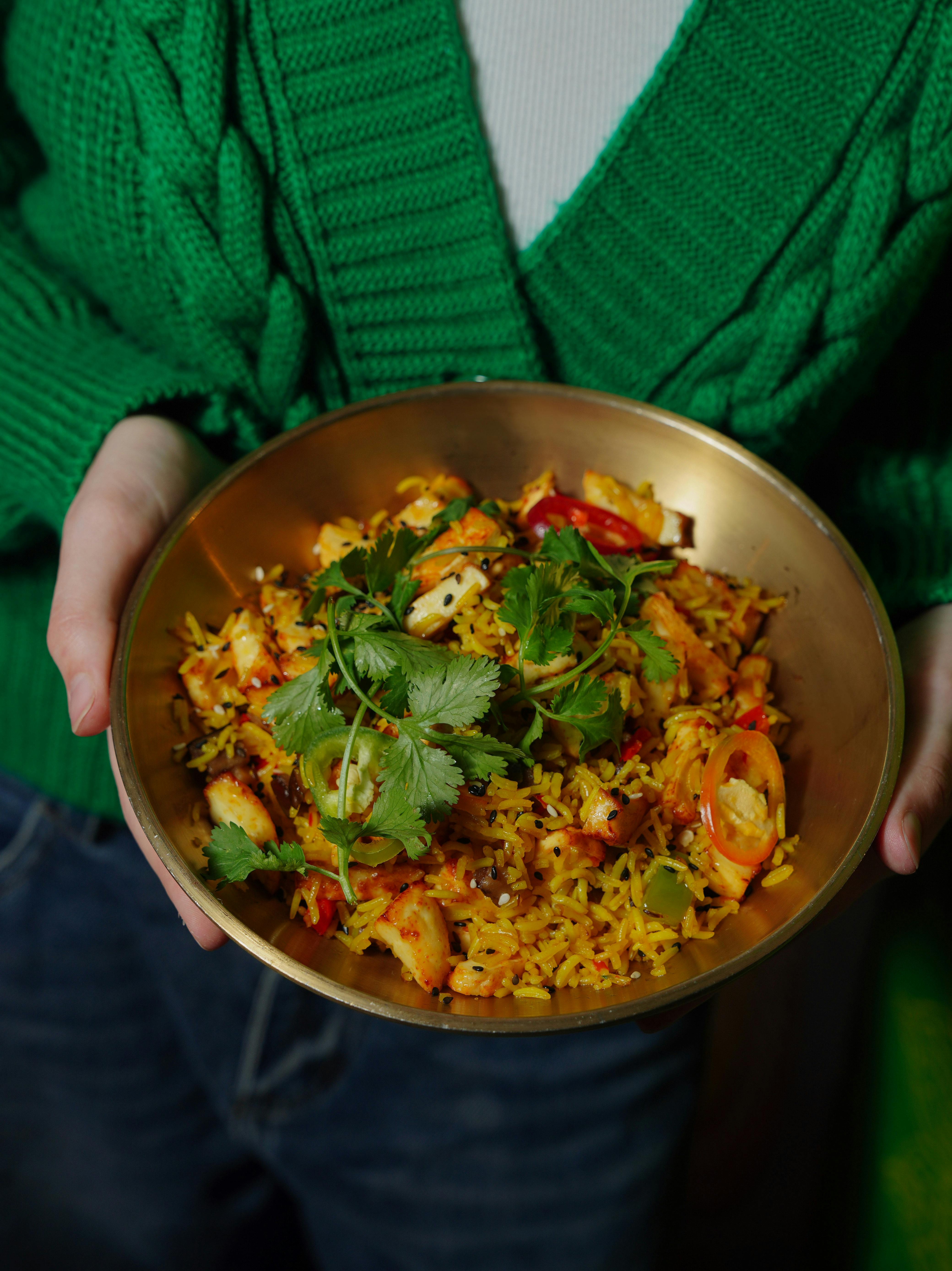 Colorful Rice Dish with Fresh Garnish Held Outdoors · Free Stock Photo