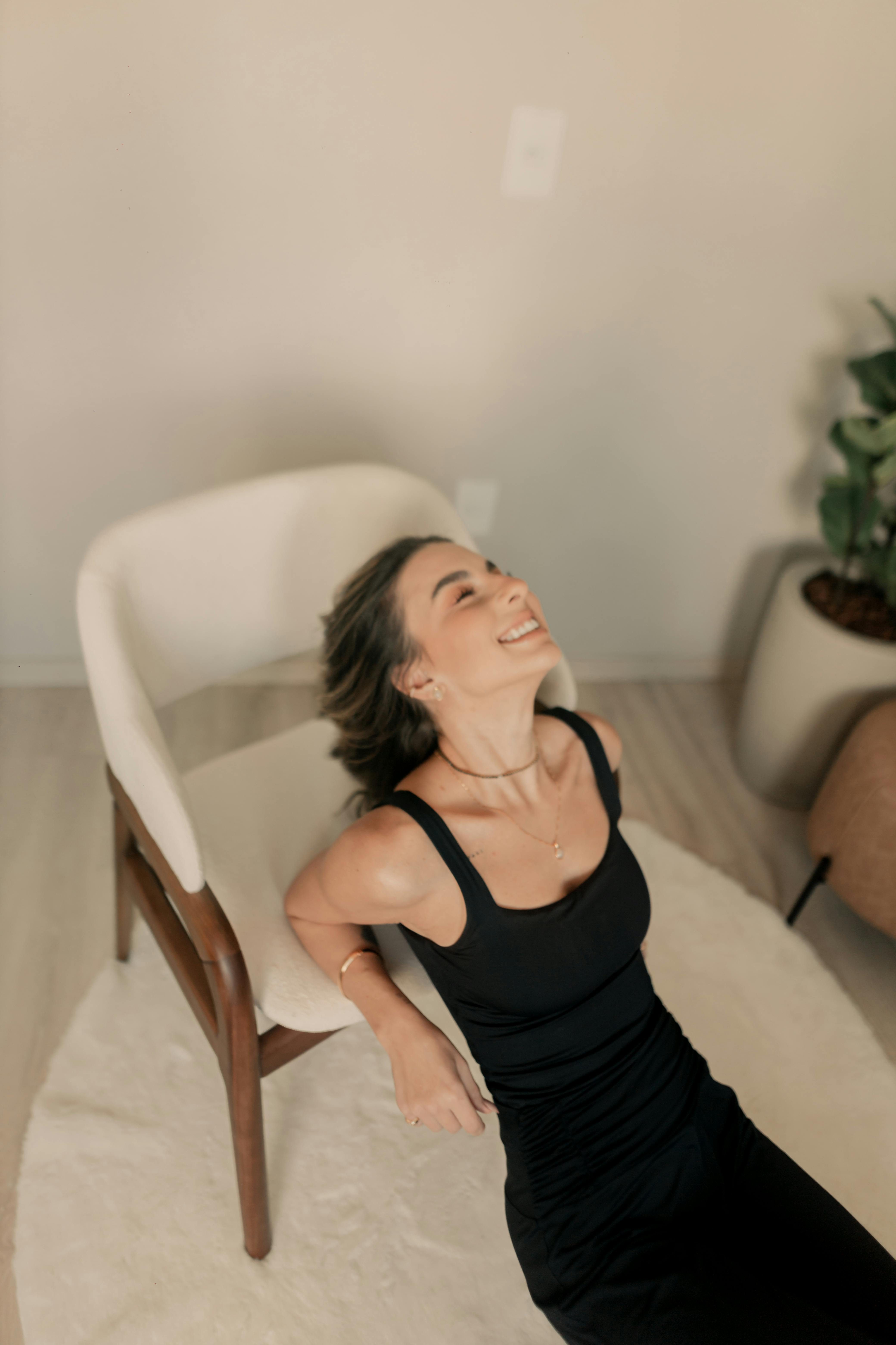 Relaxed woman leaning against chair indoors · Free Stock Photo