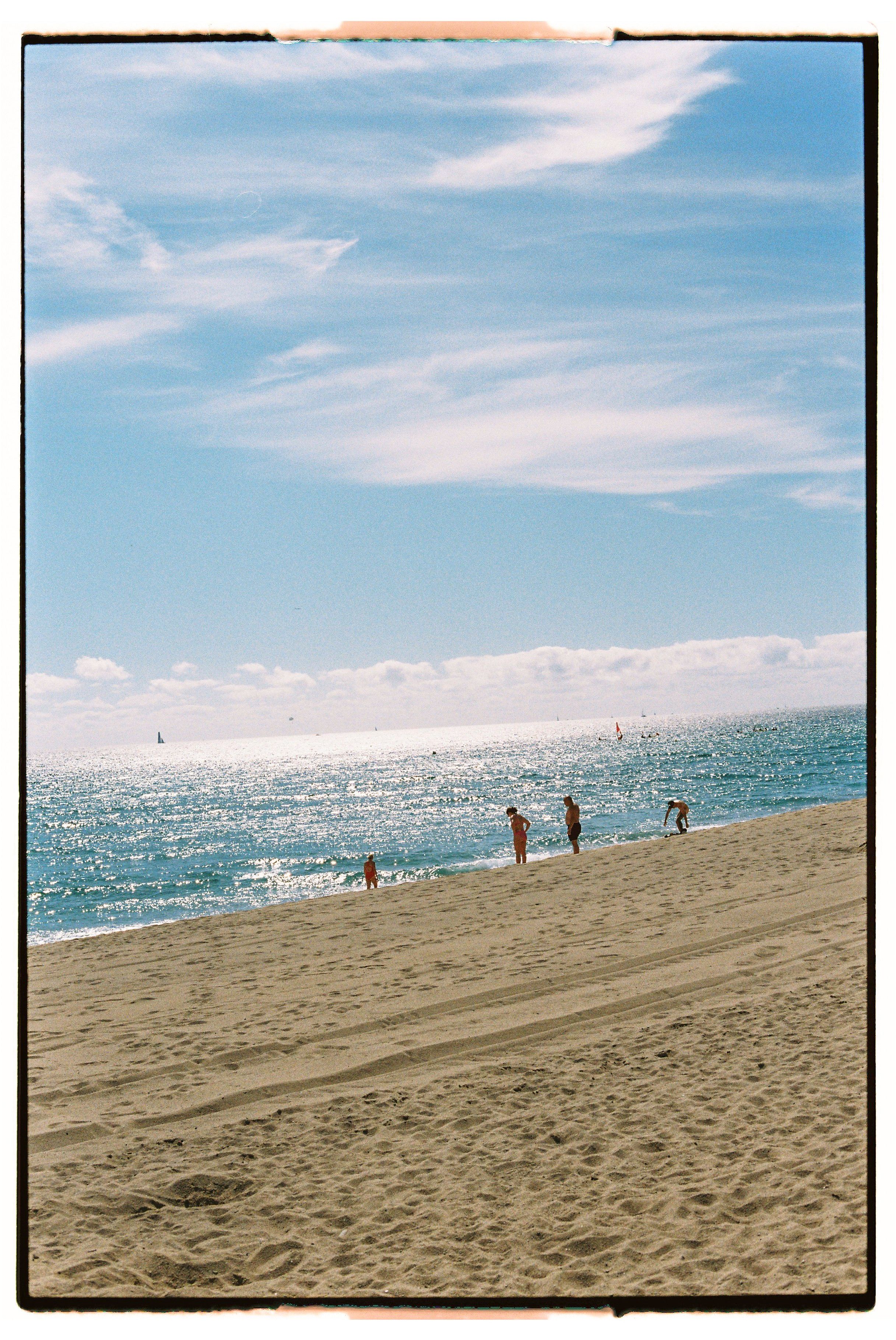 Sunny Beach Day with People by the Shore · Free Stock Photo