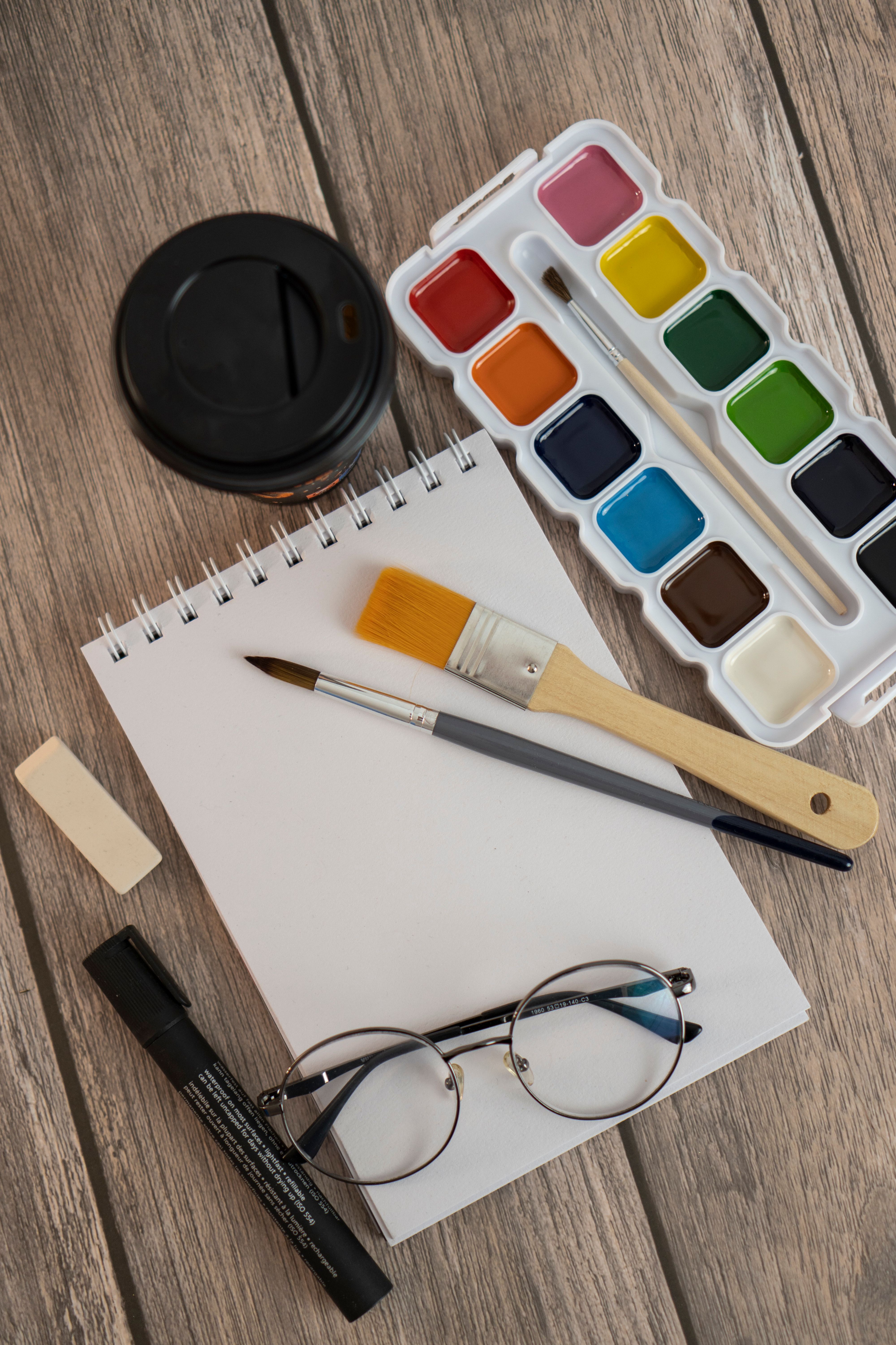 Creative workspace with art supplies on wooden table · Free Stock Photo