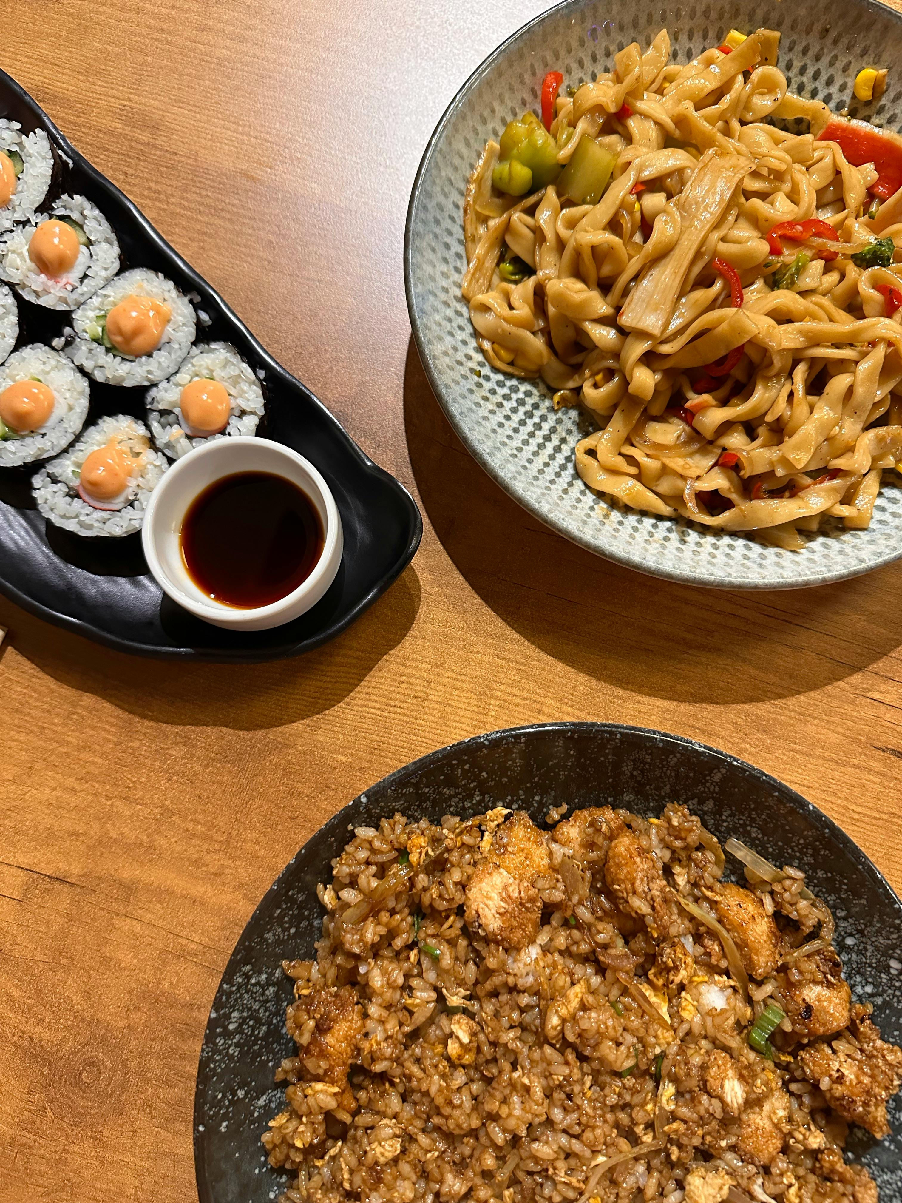 Delicious Asian Cuisine: Sushi, Noodles, Fried Rice · Free Stock Photo