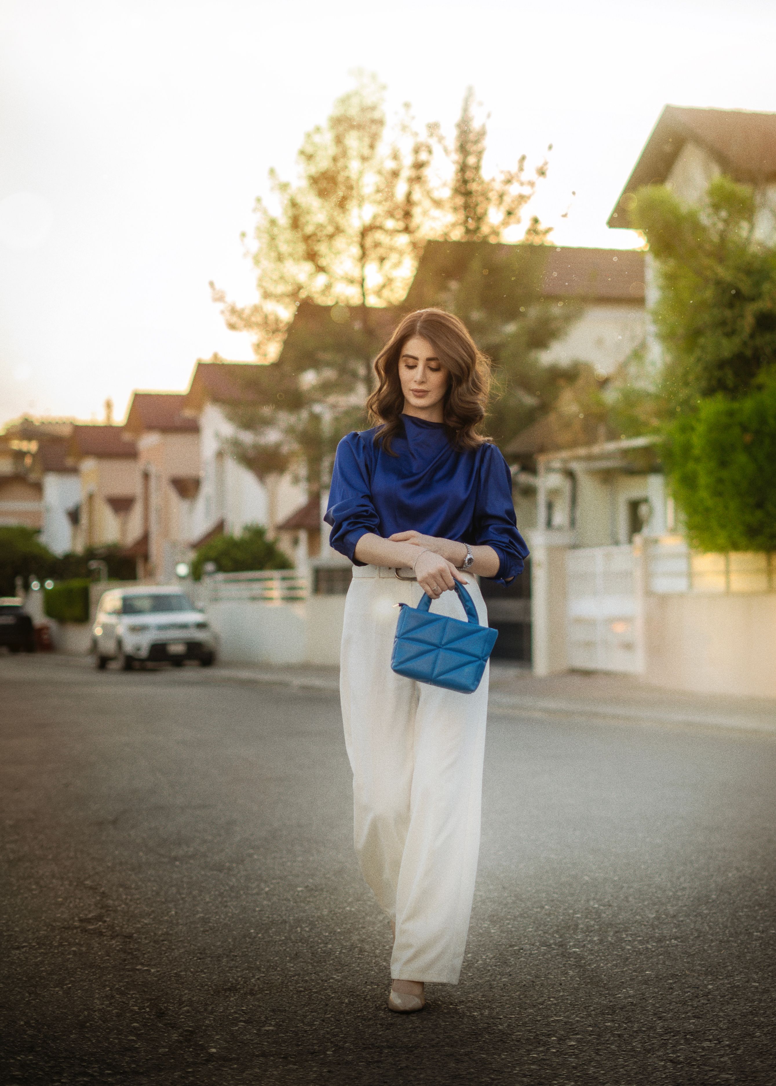 Stylish Woman Walking in Sunlit Suburban Street · Free Stock Photo