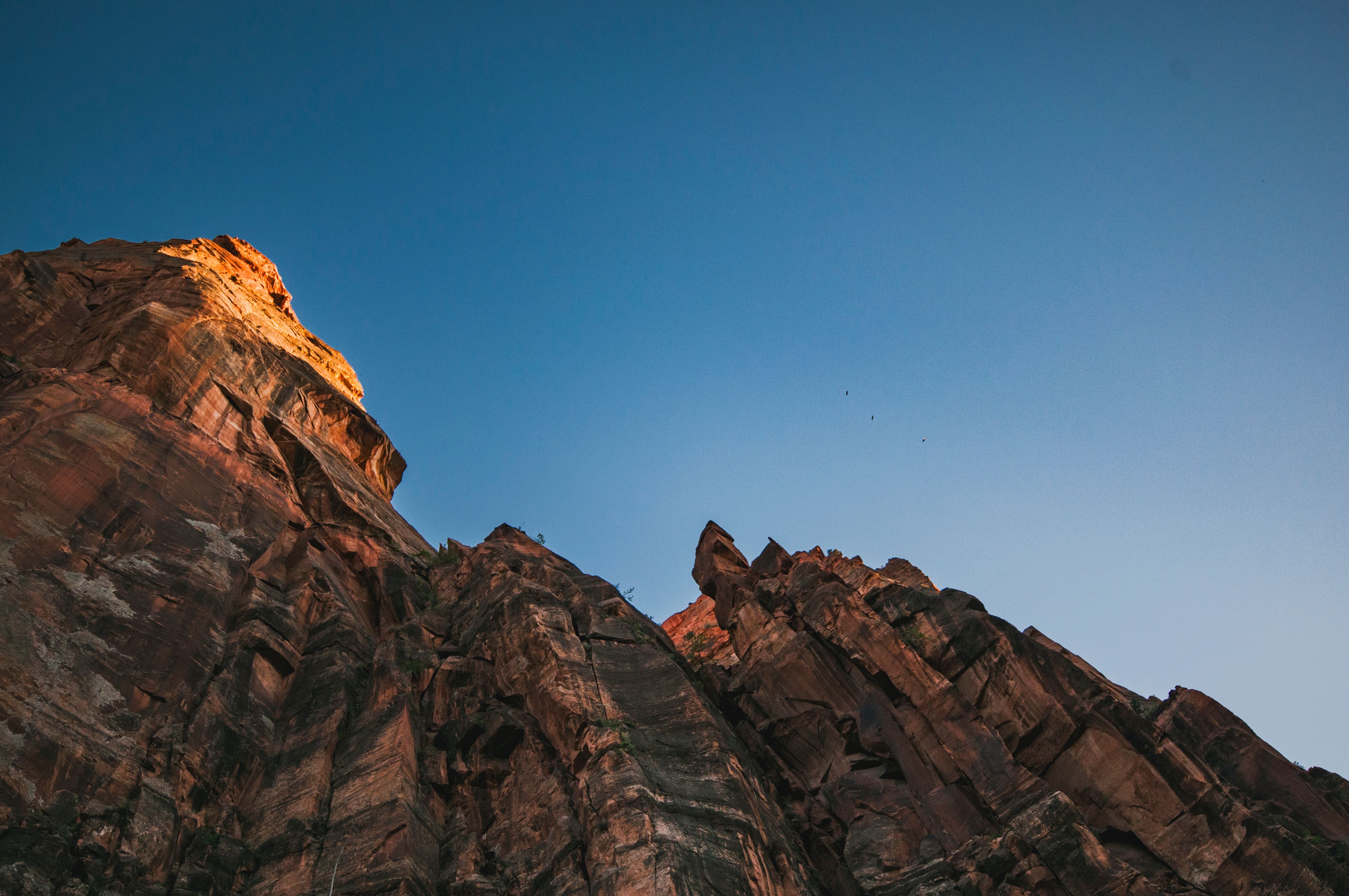 Dramatic Cliff Face Against Clear Blue Sky · Free Stock Photo