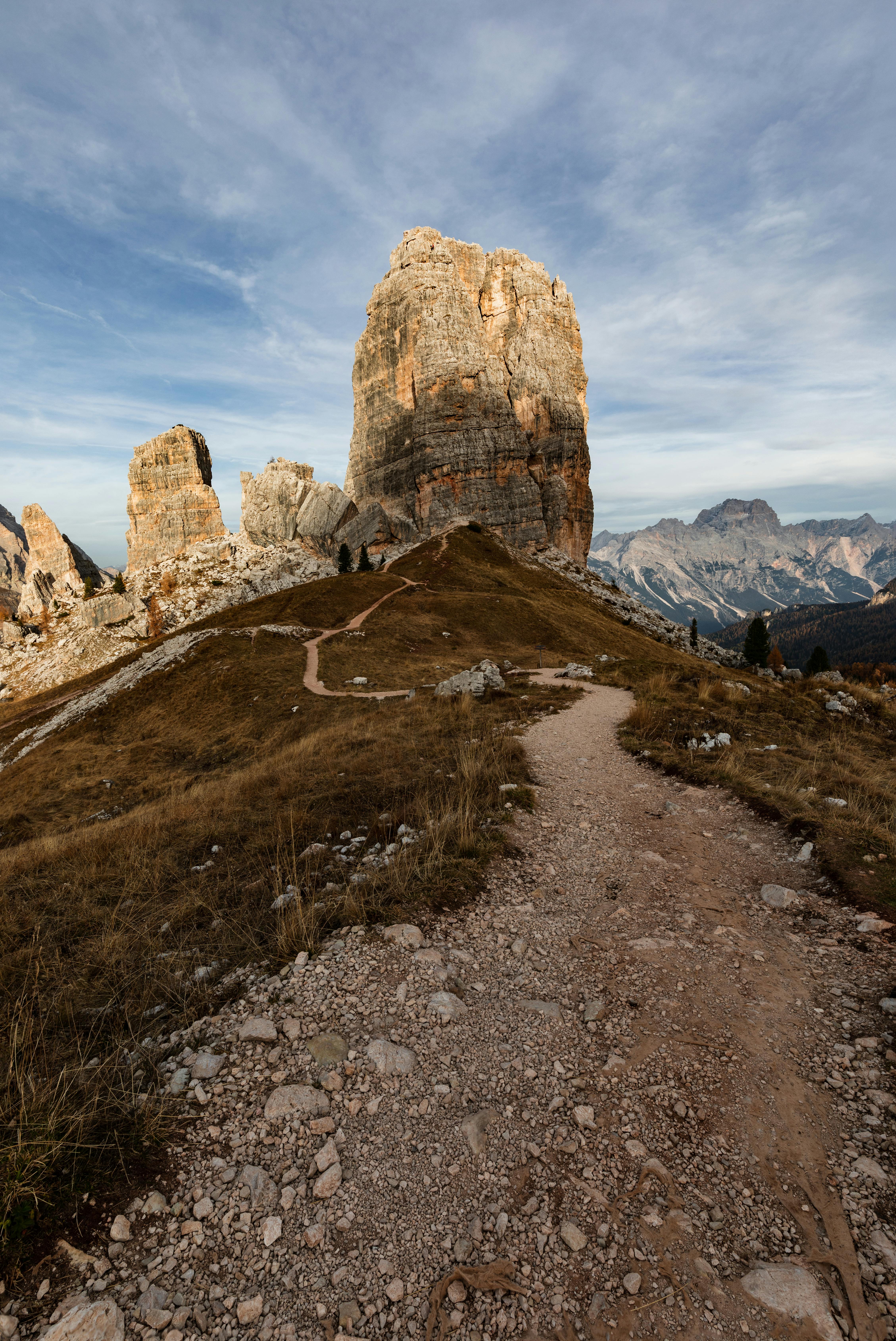 Scenic Mountain Path Leading to Towering Rock Formation · Free Stock Photo