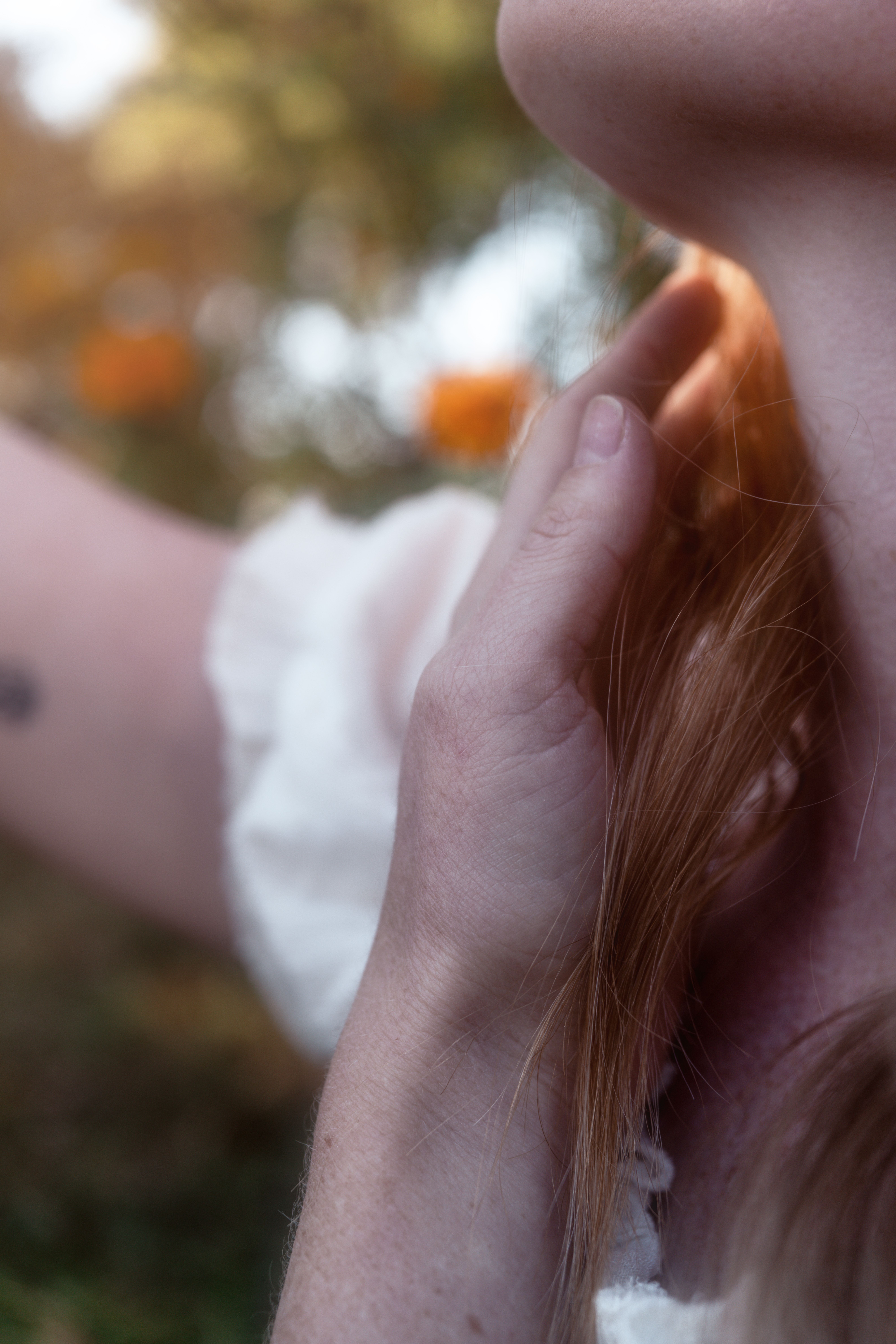 Close-Up of Hand Gently Touching Neck Outdoors · Free Stock Photo