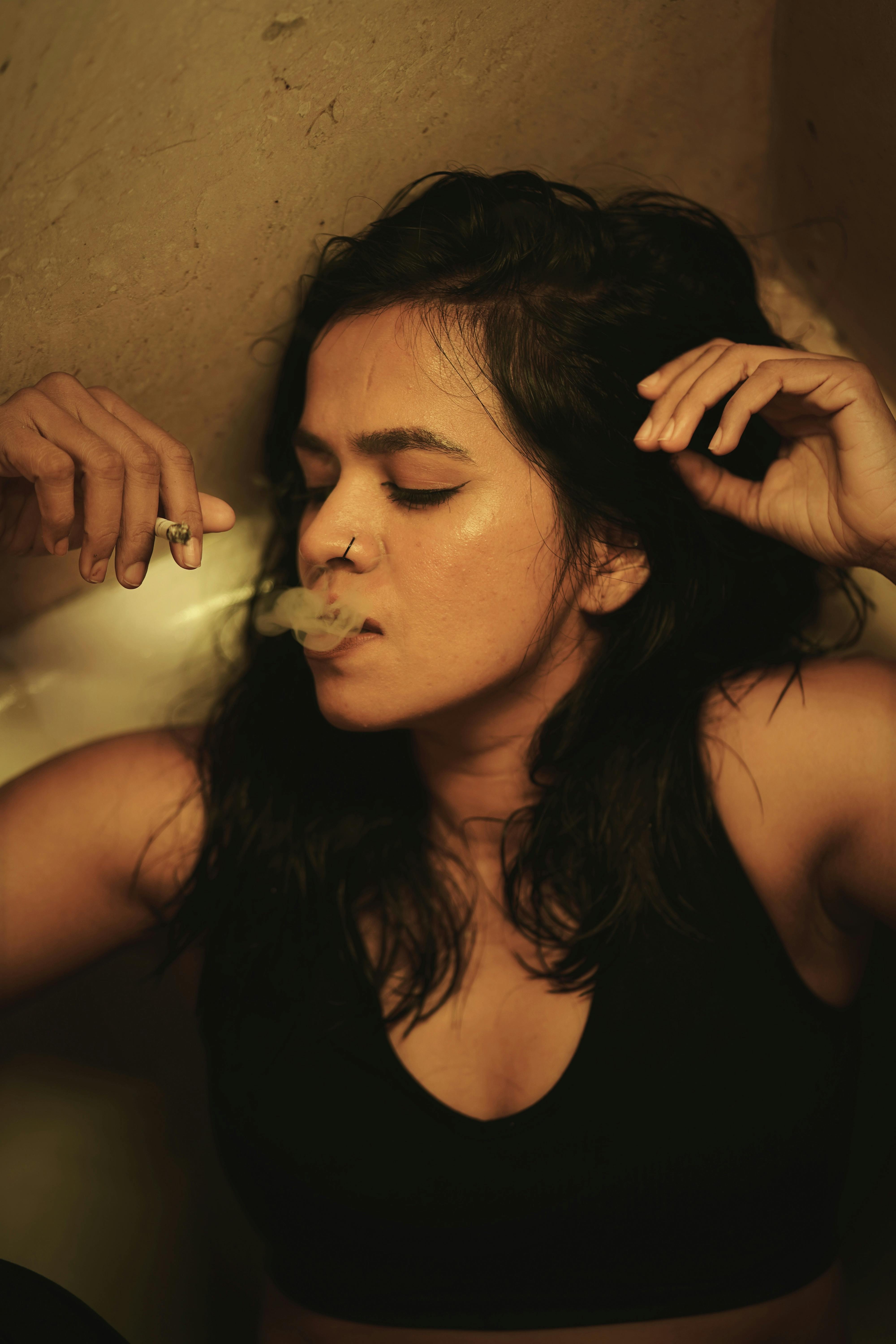 Woman Relaxing and Smoking in Indoor Setting · Free Stock Photo