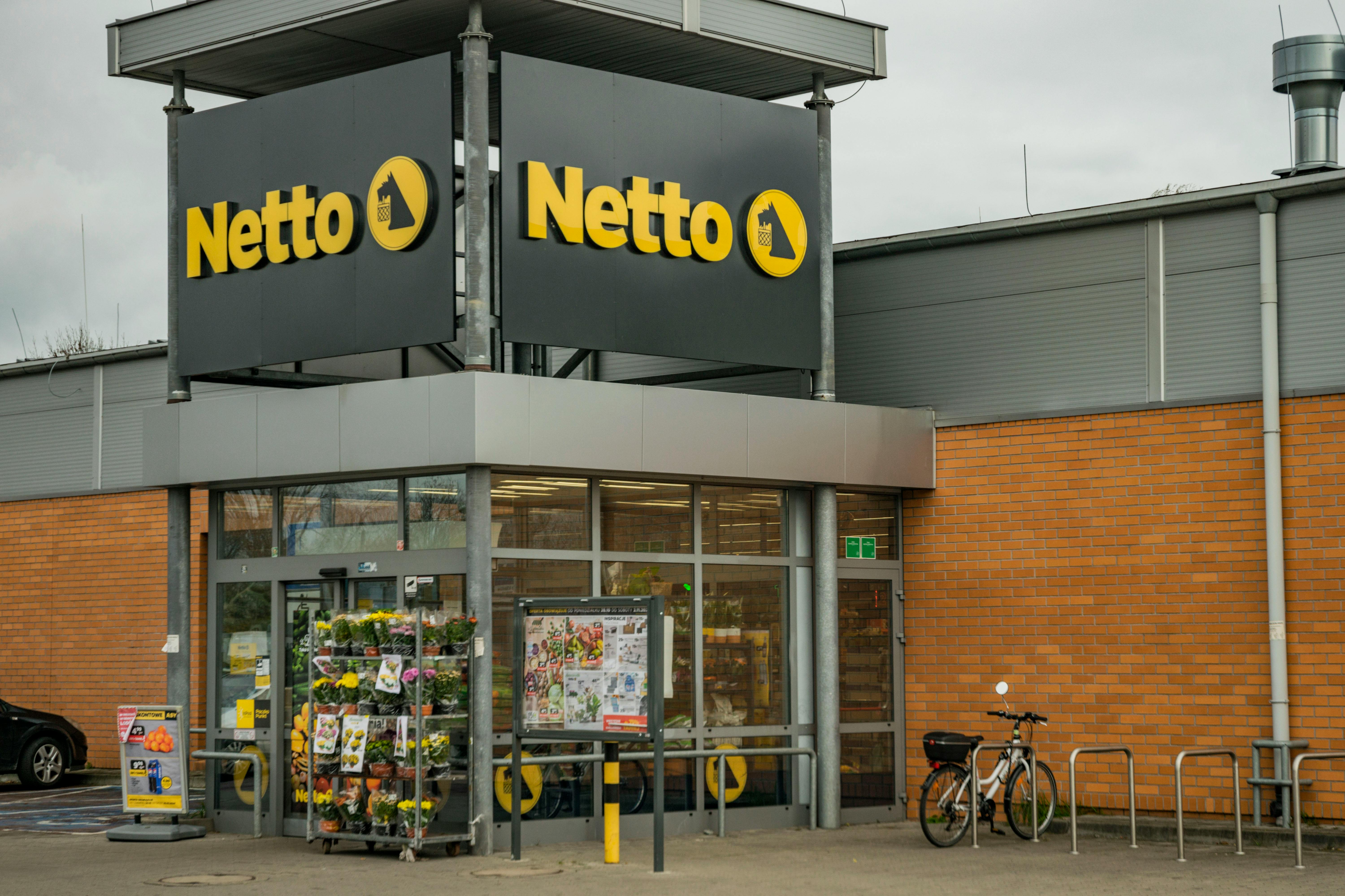 Netto Storefront with Bicycles and Brick Wall · Free Stock Photo