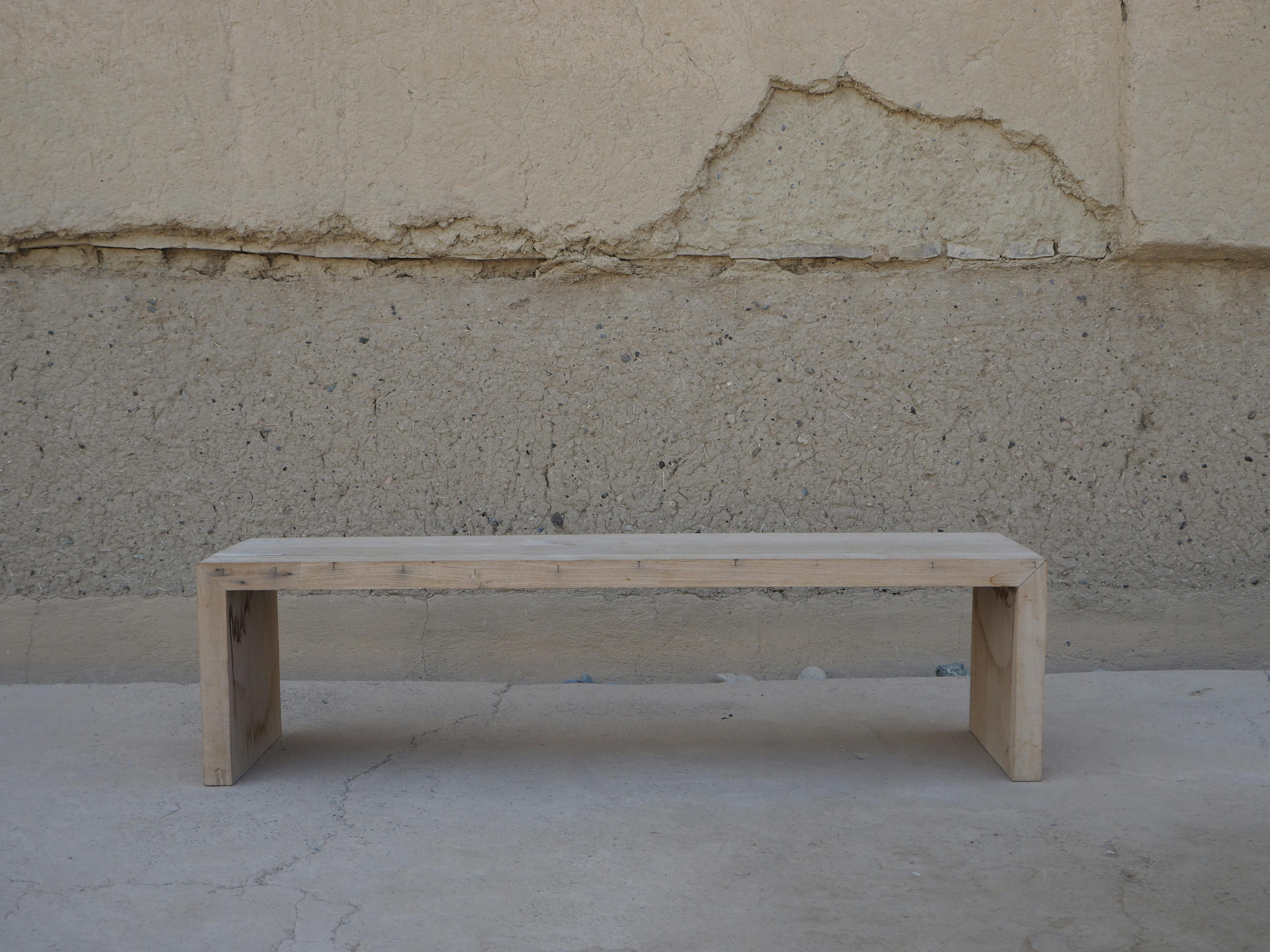 Minimalist Wooden Bench Against Textured Wall · Free Stock Photo