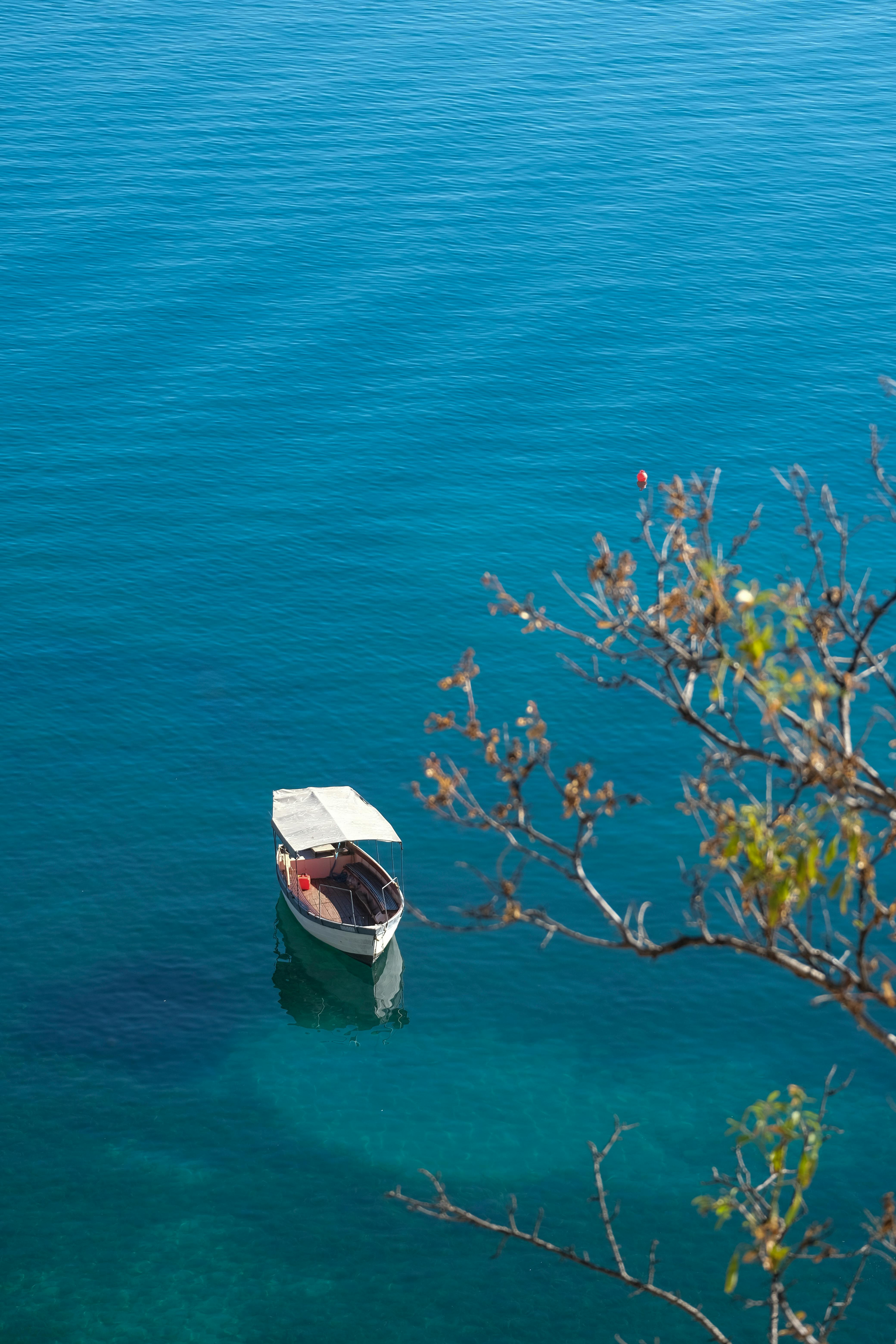 Tranquil Boat Floating on Calm Blue Sea · Free Stock Photo