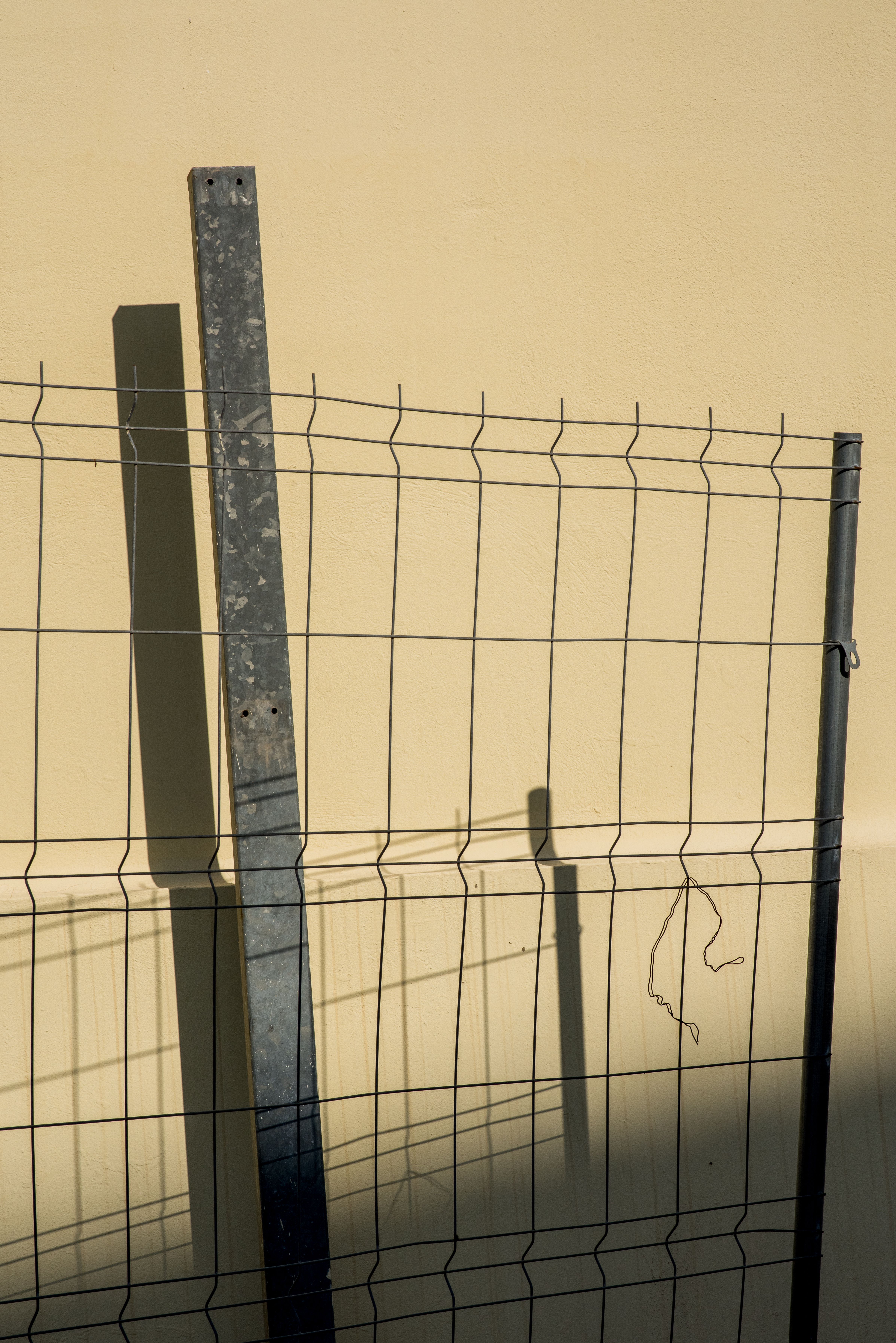 Sunny Fence Shadows on a Yellow Wall · Free Stock Photo