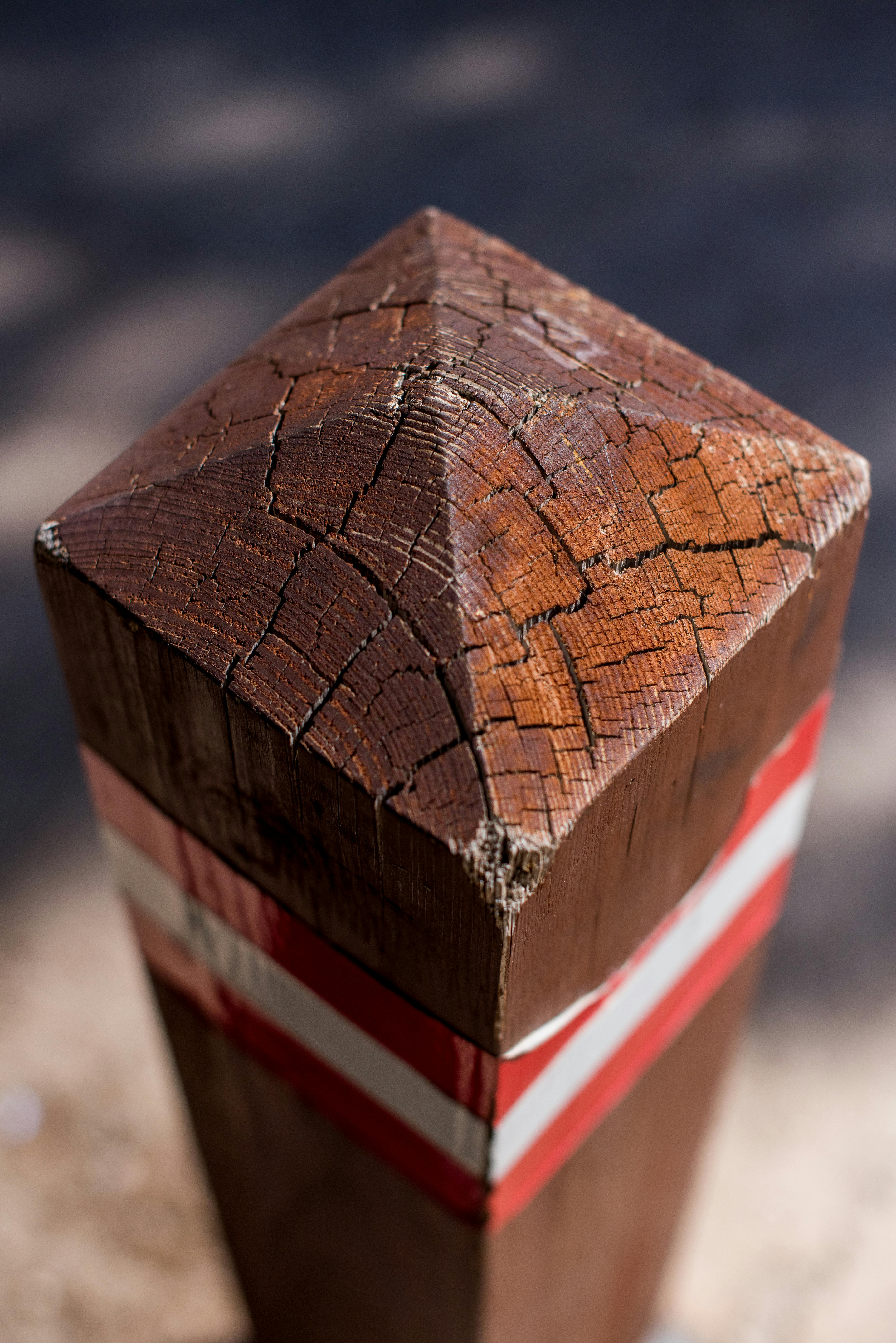 Close-up of Weathered Wooden Post with Red Stripe · Free Stock Photo