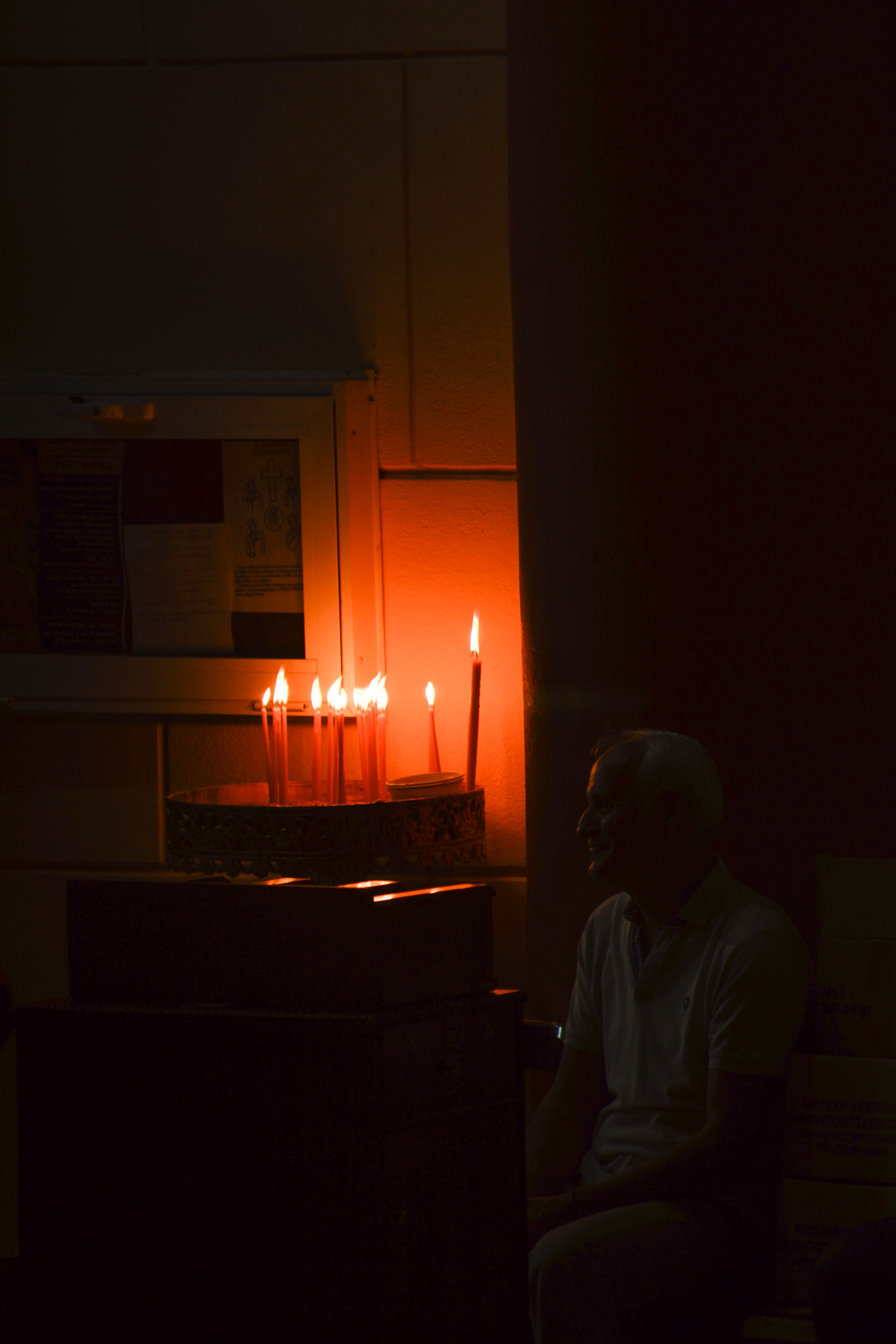 Elderly Man Contemplating by Candlelight in a Dark Room · Free Stock Photo