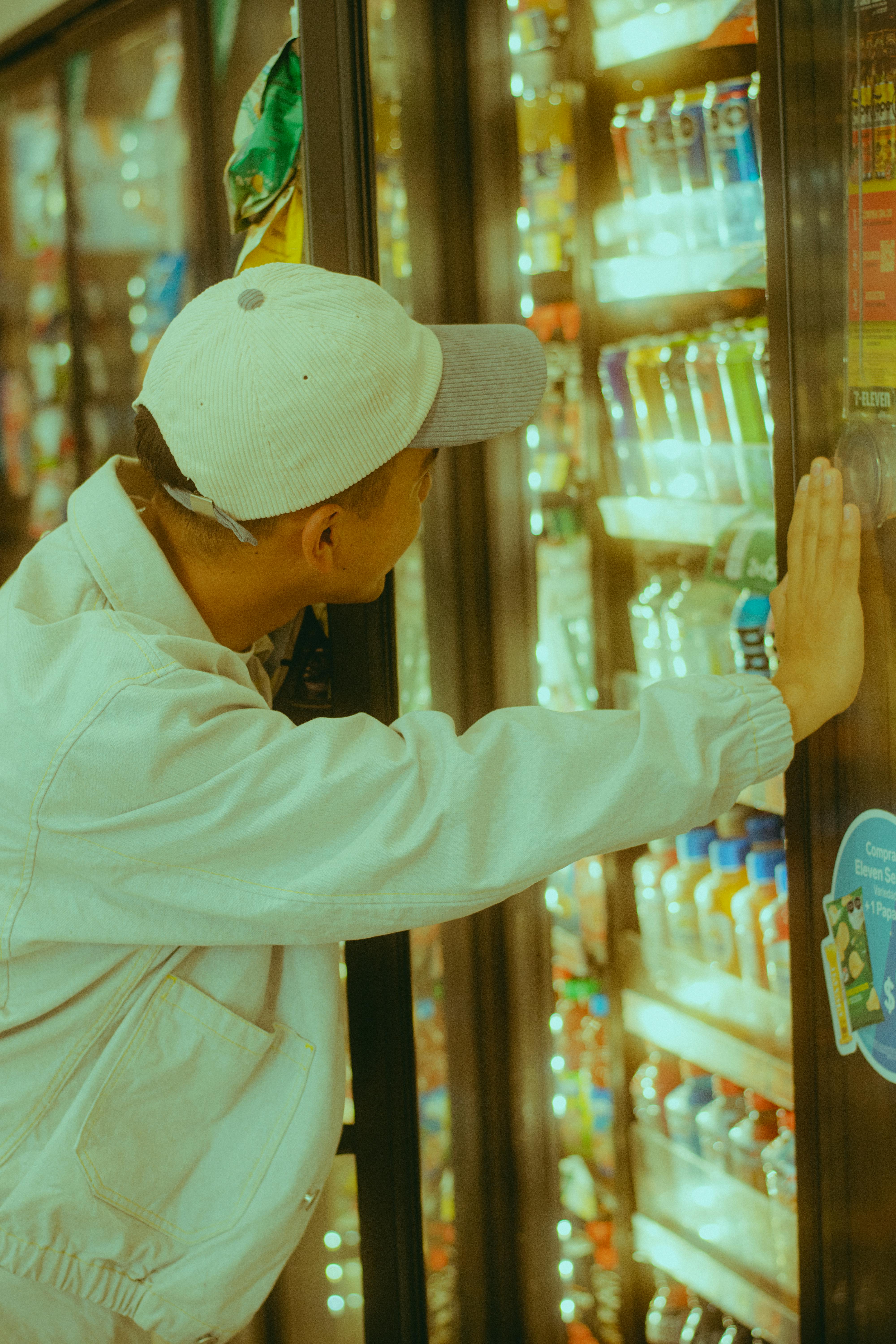 Person Looking at Refreshments in Cooler at Store · Free Stock Photo