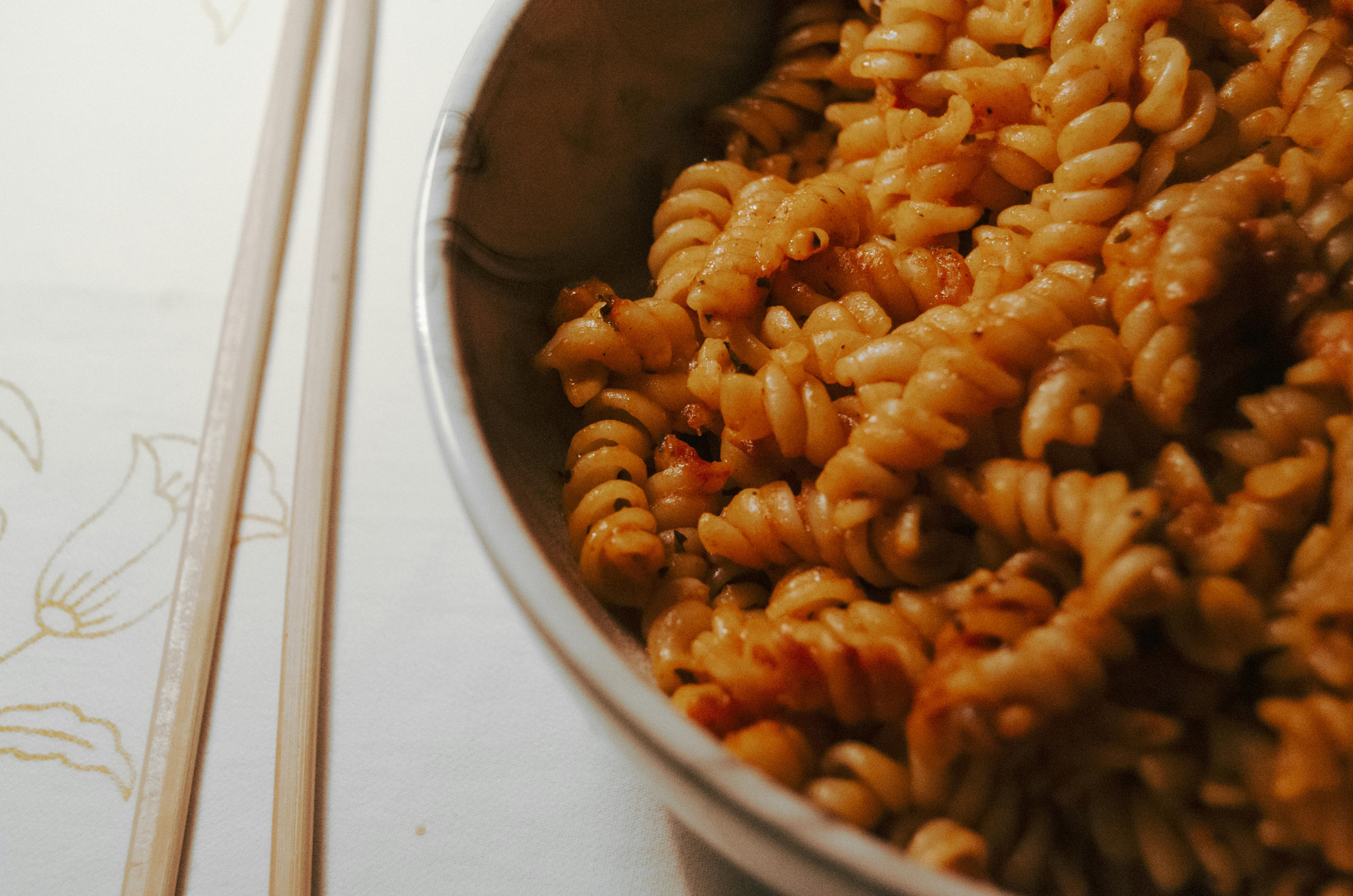 Delicious Rotini Pasta Dish with Chopsticks · Free Stock Photo